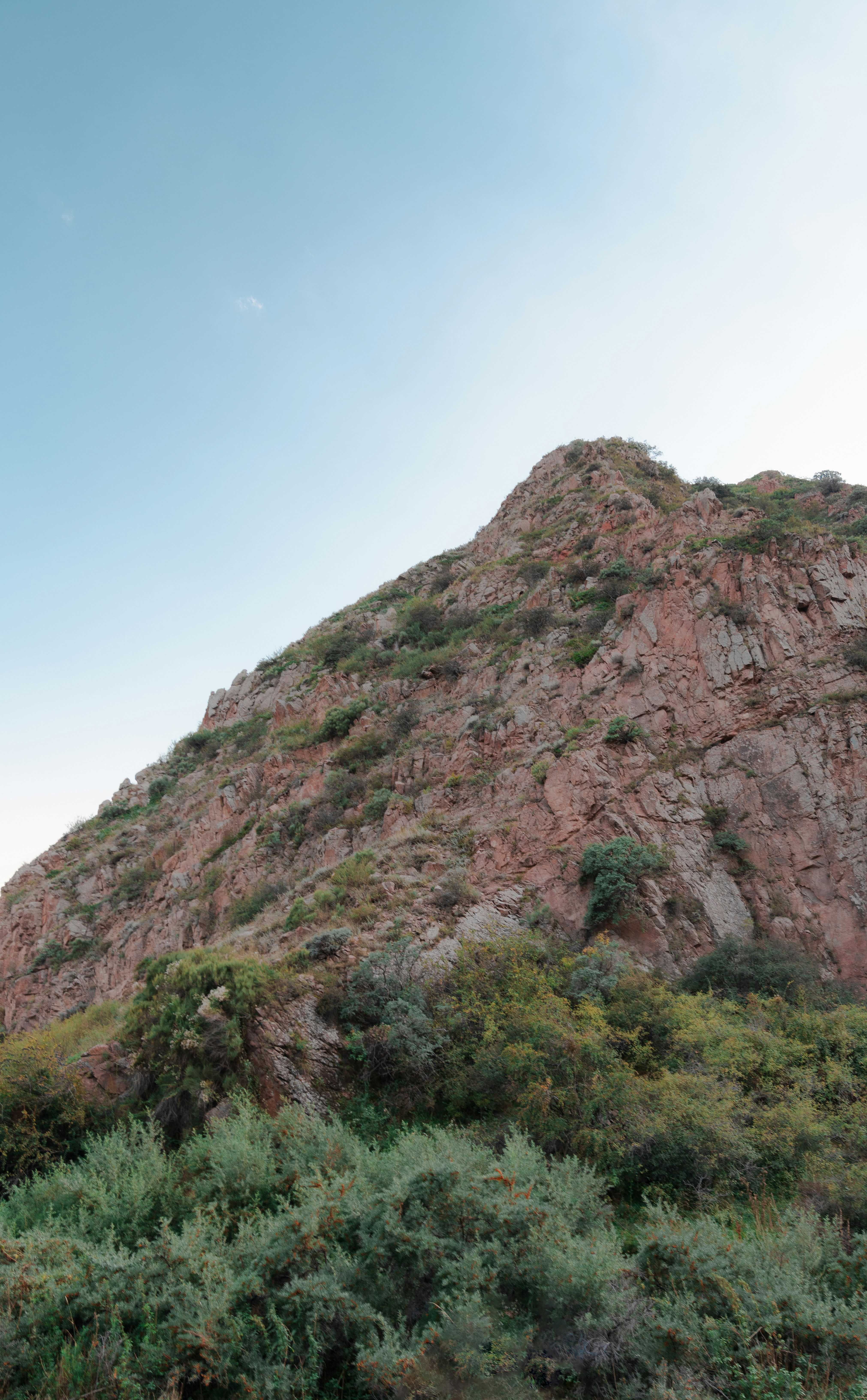 Rugged Summit: A Red Rock Cliff Reaching Toward a Clear Sky
