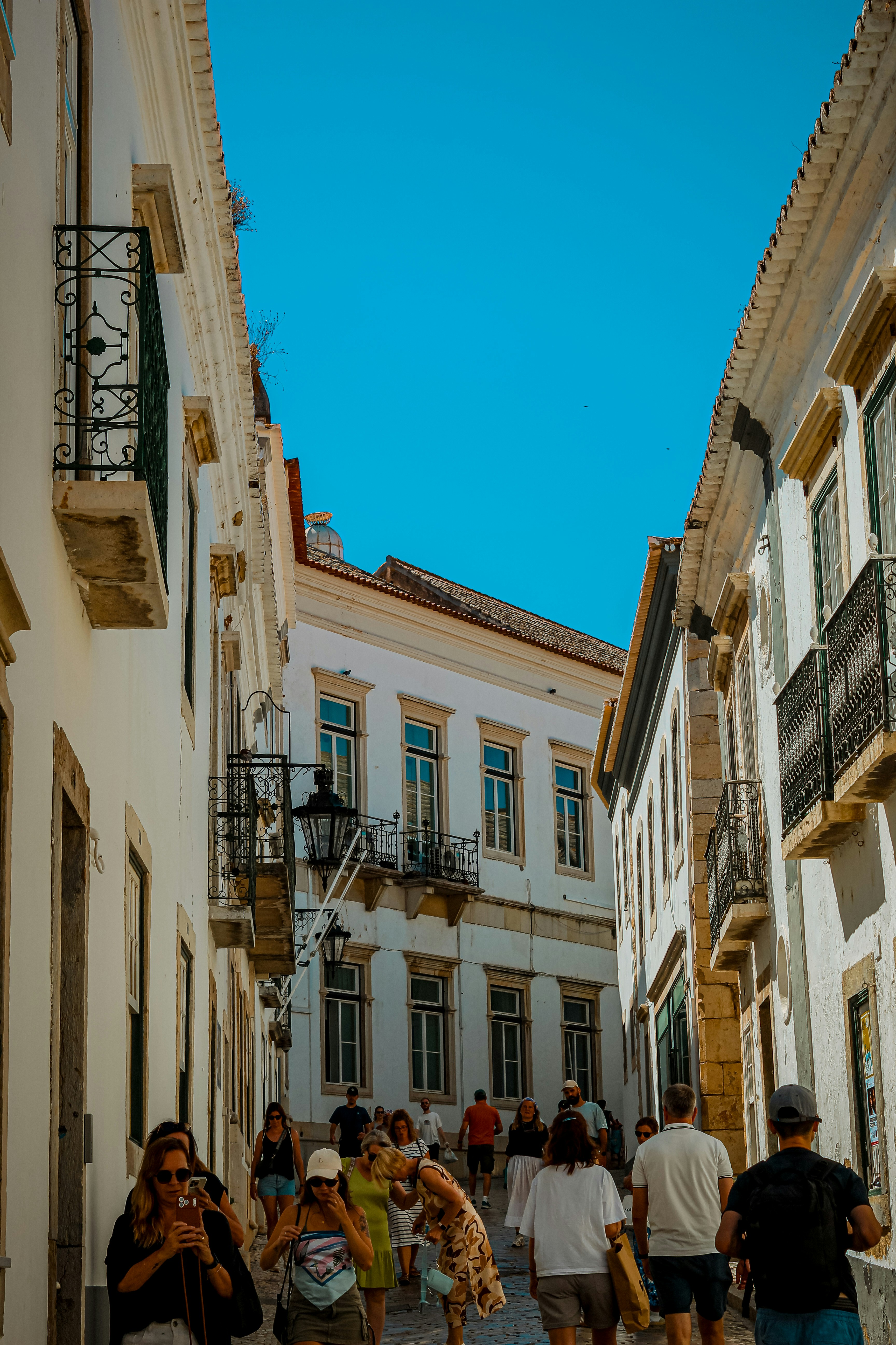 Sunlit Calle of Tourists: A Quiet Moment Amid Historic Facades