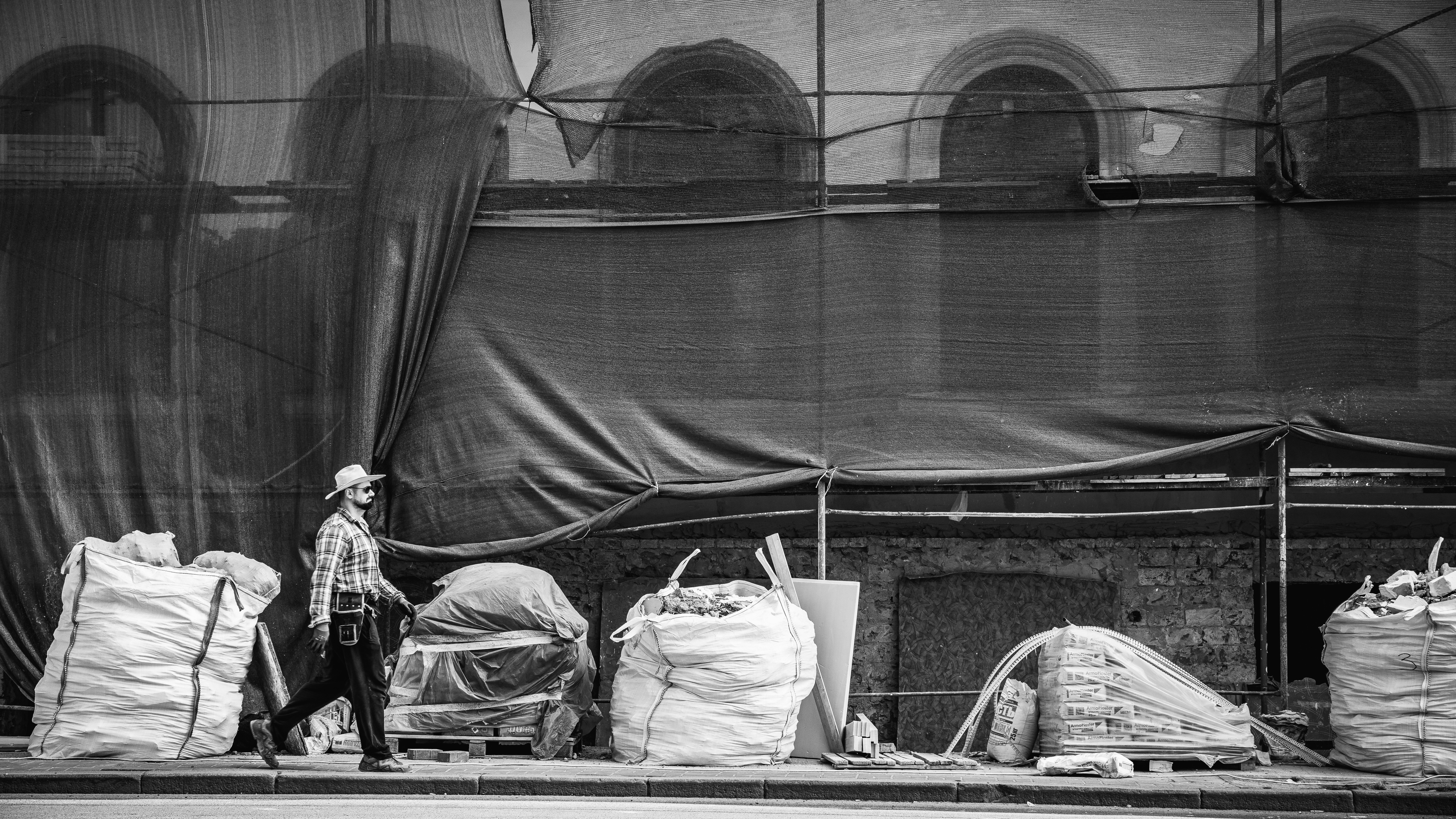 Dust and Determination: Worker in a Caged Construction Yard