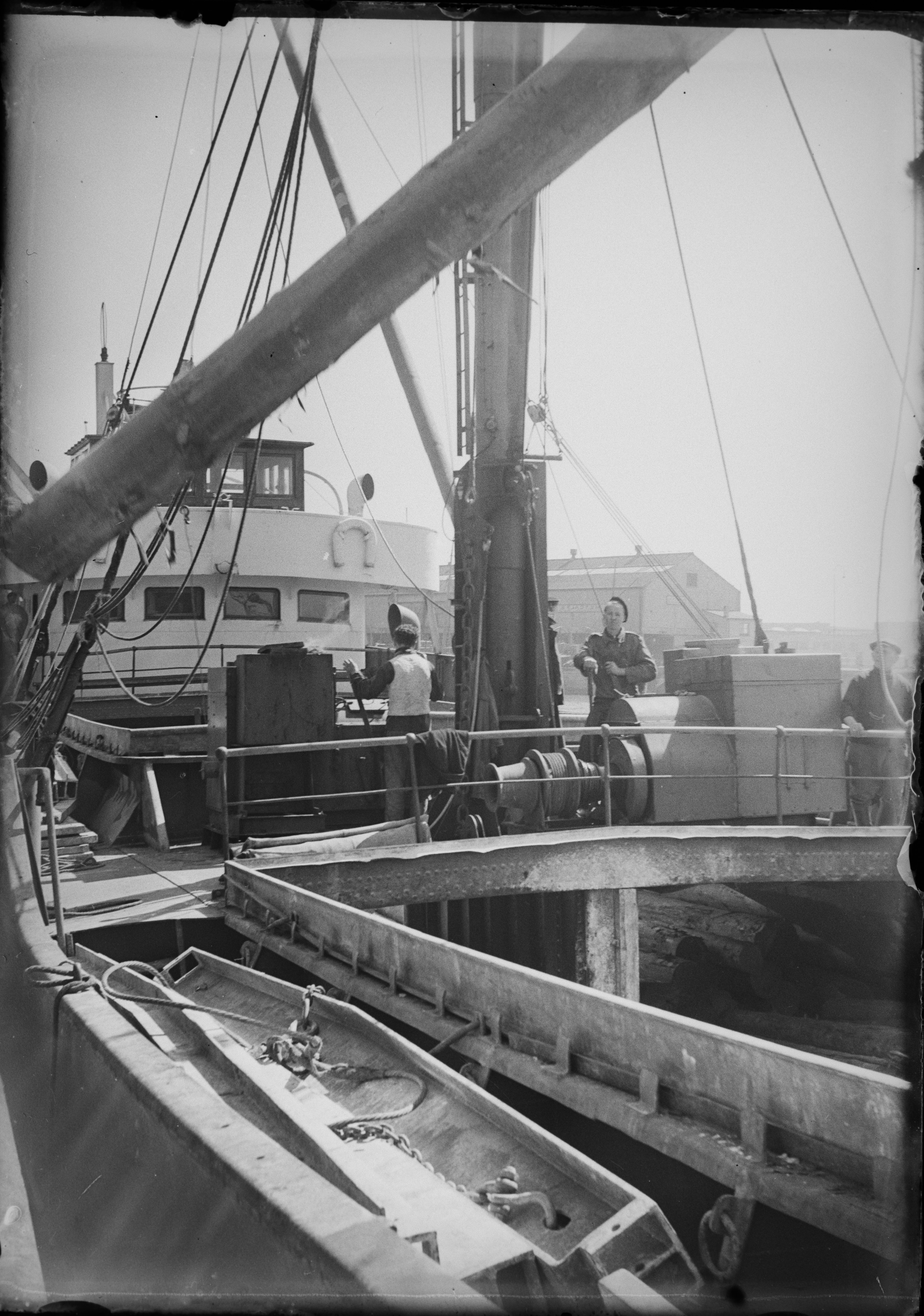 Dockside Echoes: Sailors at Work Amid Masts and Machinery