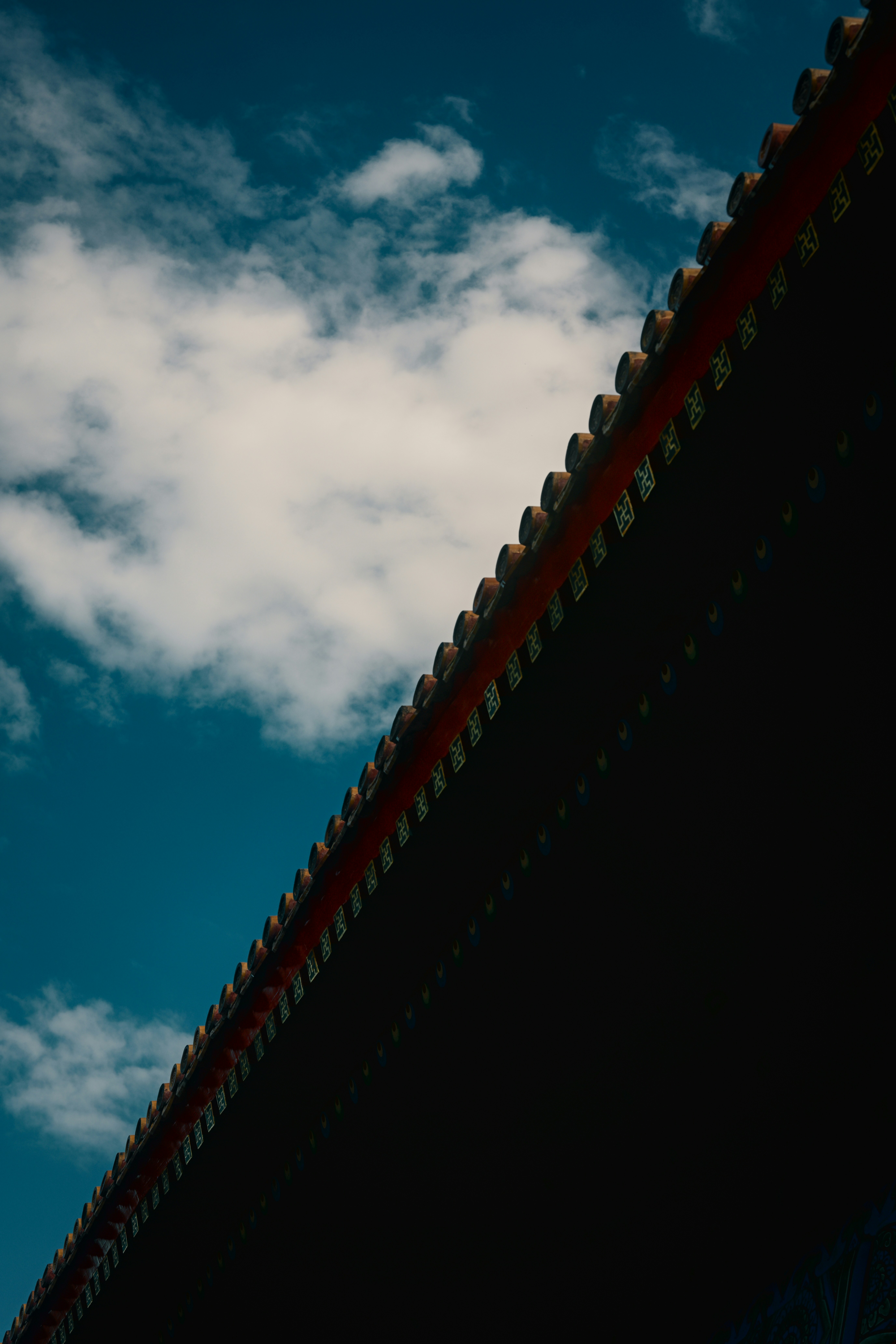 Red Tile Roof Leading Edge Slant Over a Clear Sky