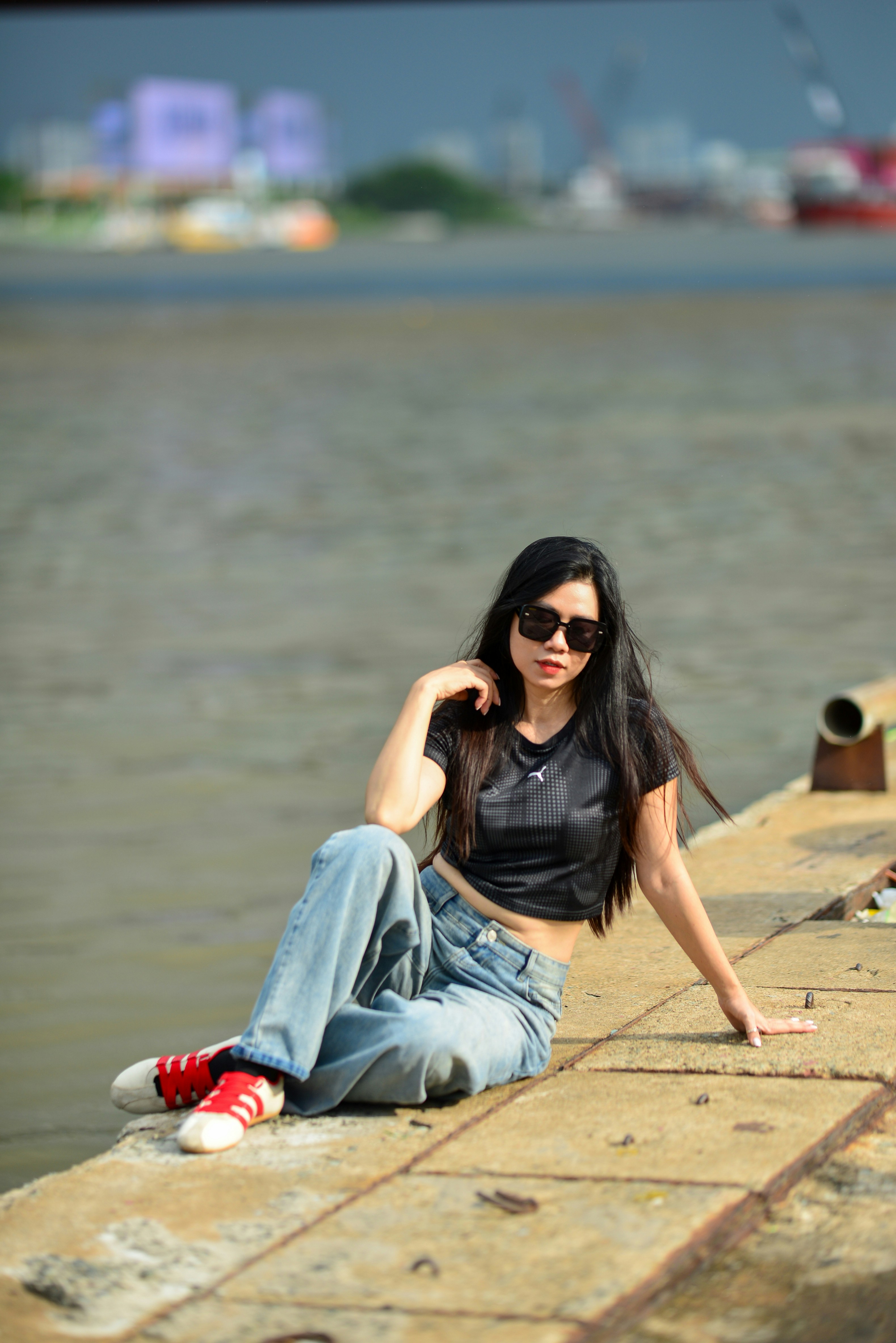 Woman lounging on a weathered dock by calm water