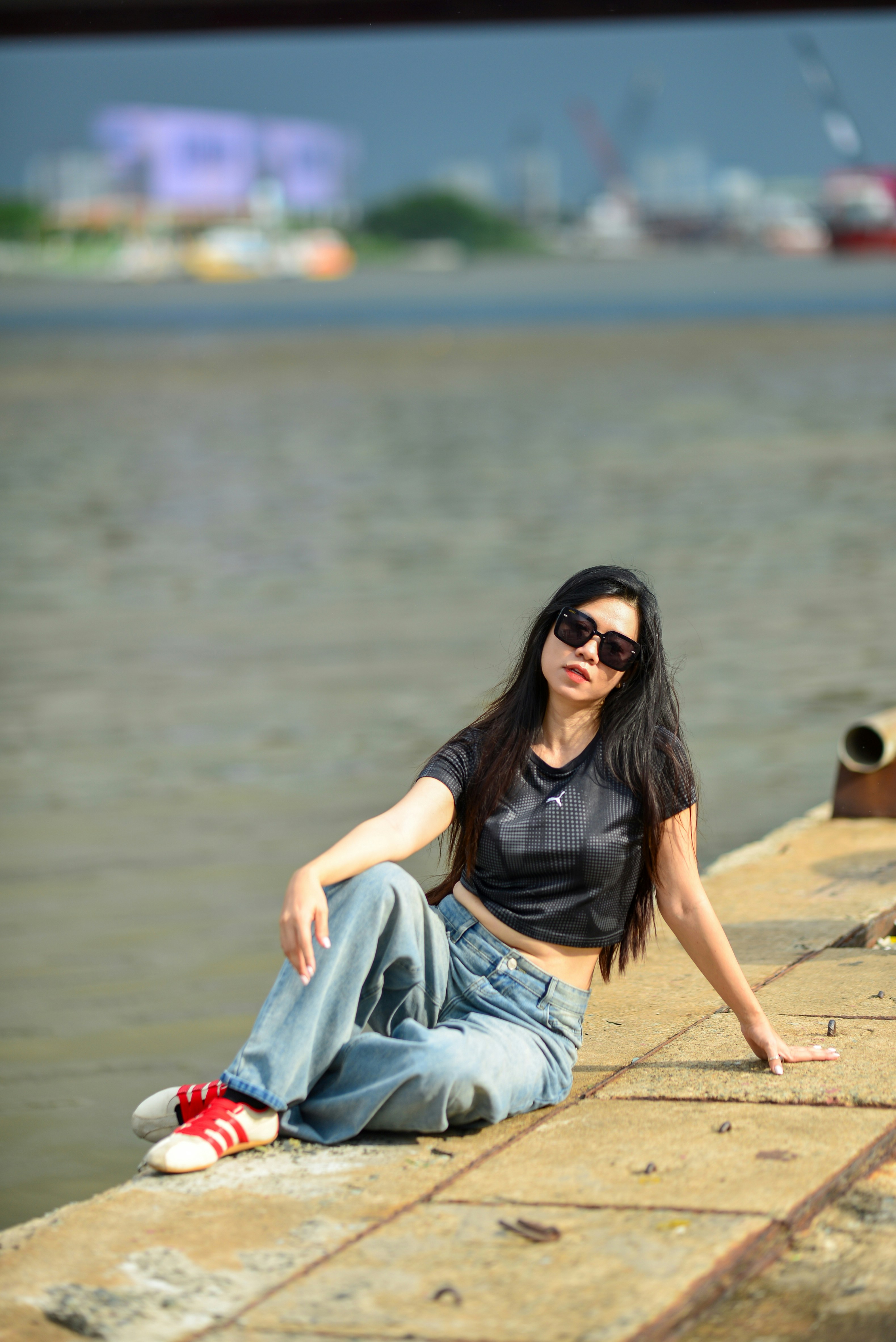 Sunlit Confidence: A Woman Lounges on a Waterfront Pier