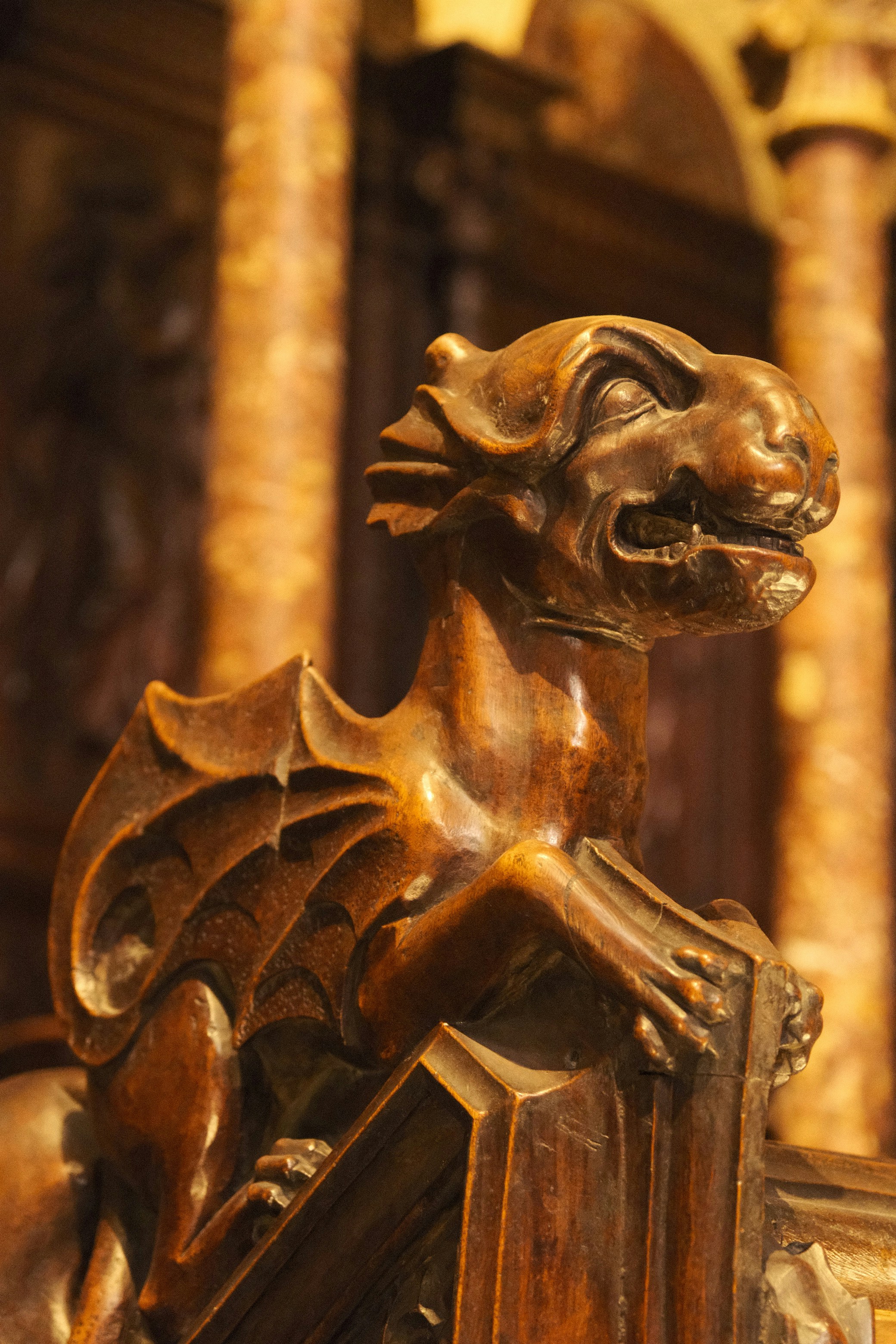 Bronze dragon statue perched on a carved pedestal, ornate architectural columns in the background.