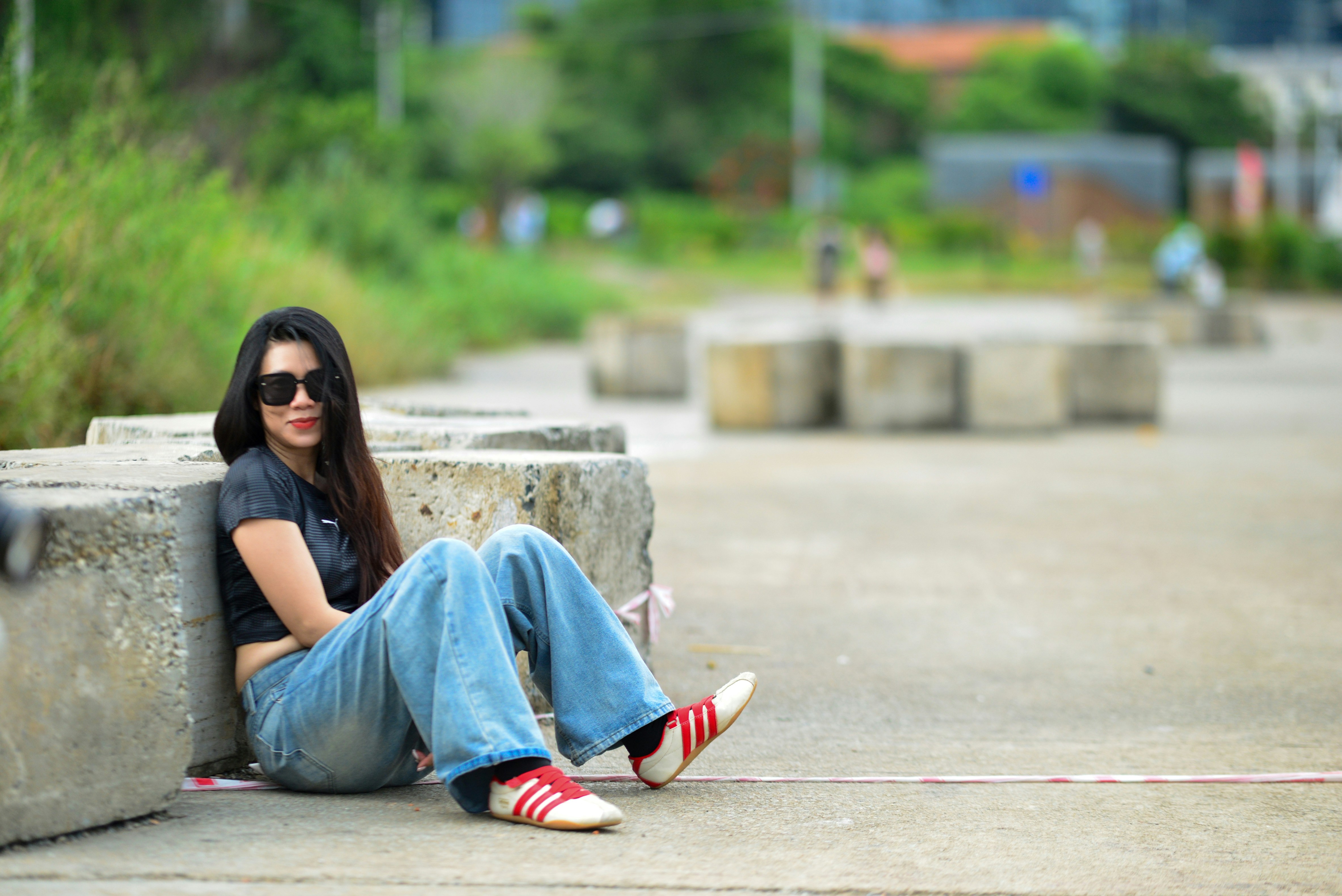 Casual pose by weathered blocks under an open sky