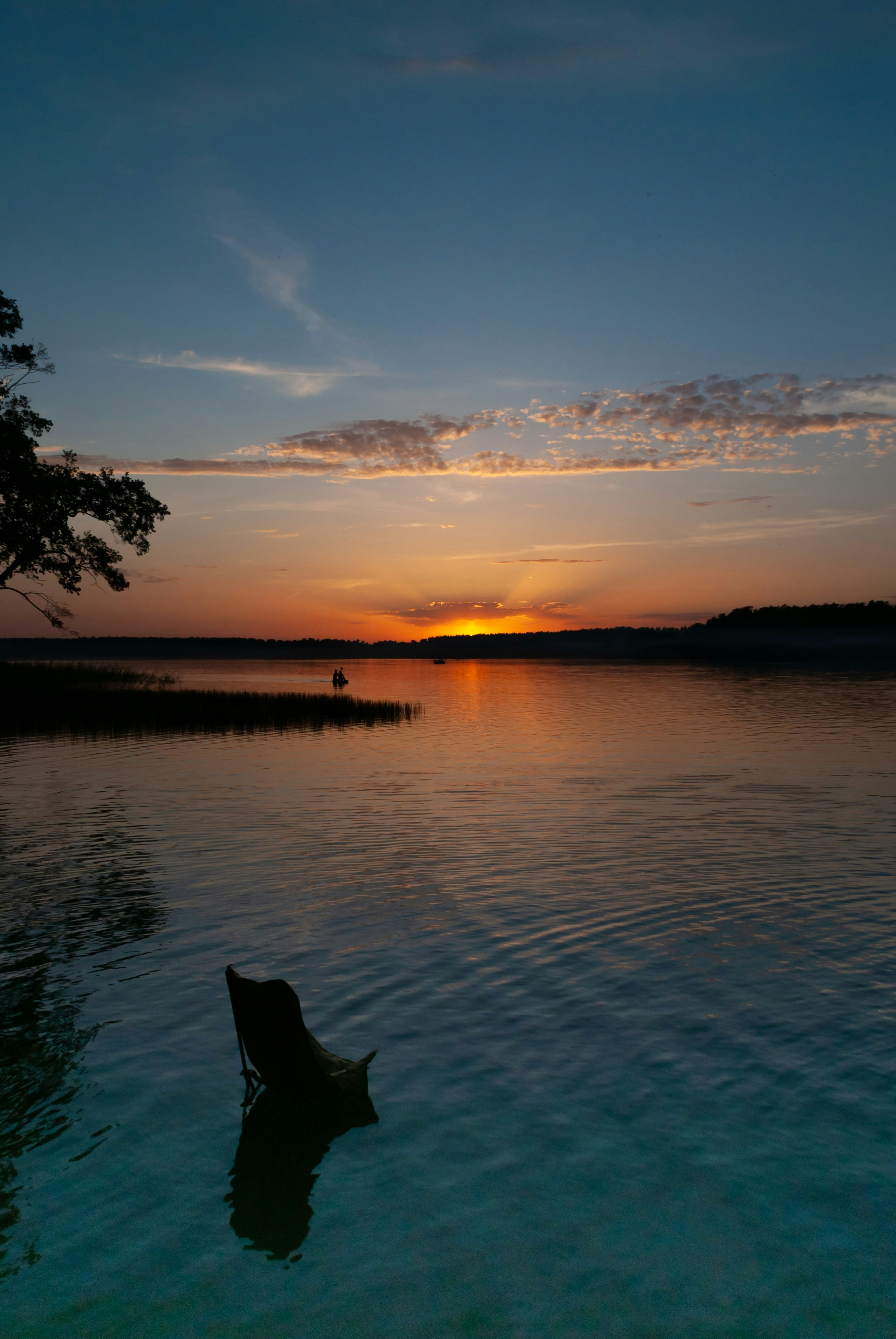 Sunset Silhouette Over Quiet Lake with a Floating Log