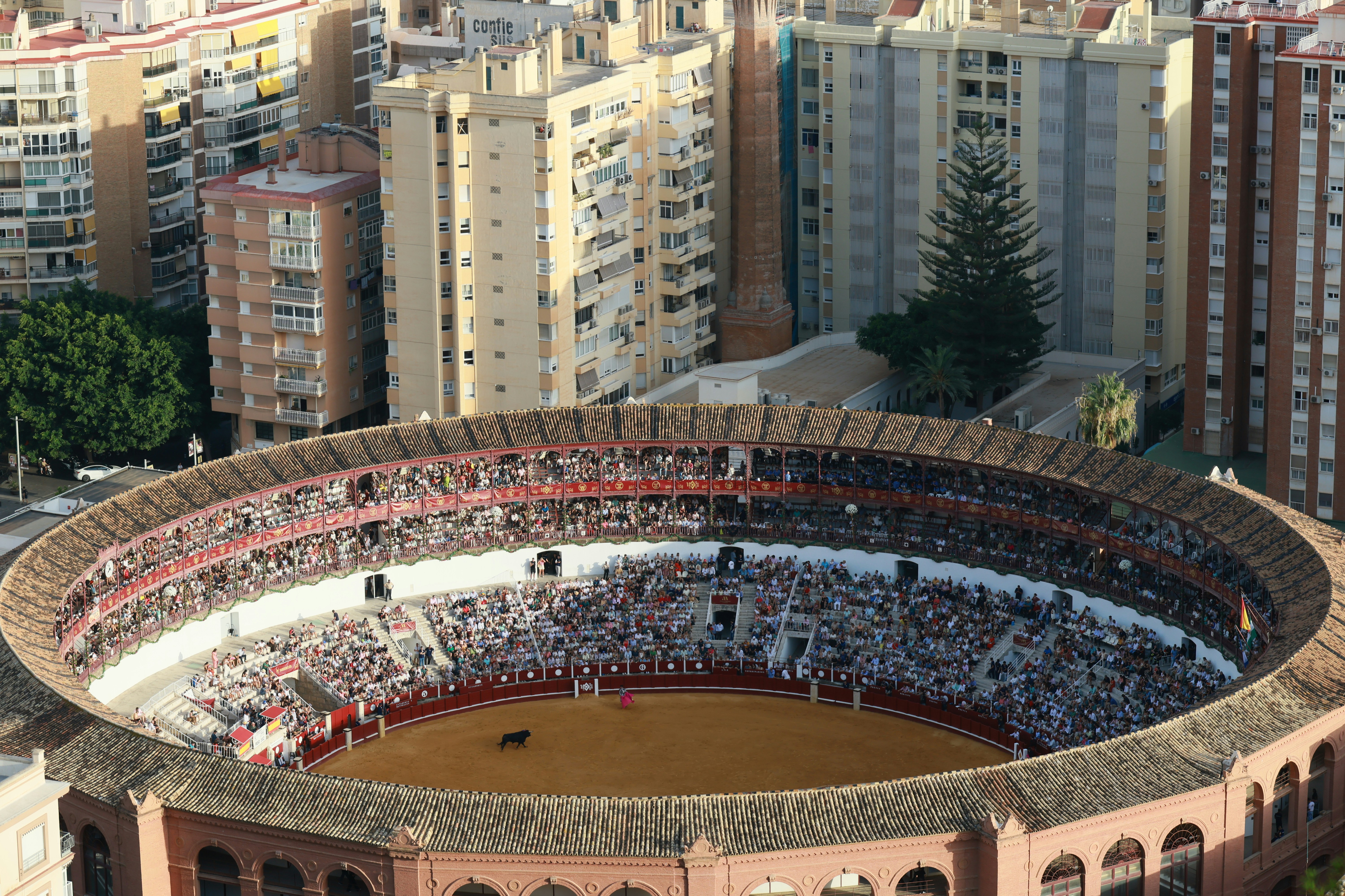 Echoes of the Arena: Aerial View of a Historic Bullring Surrounded by High-Rrise Moons
