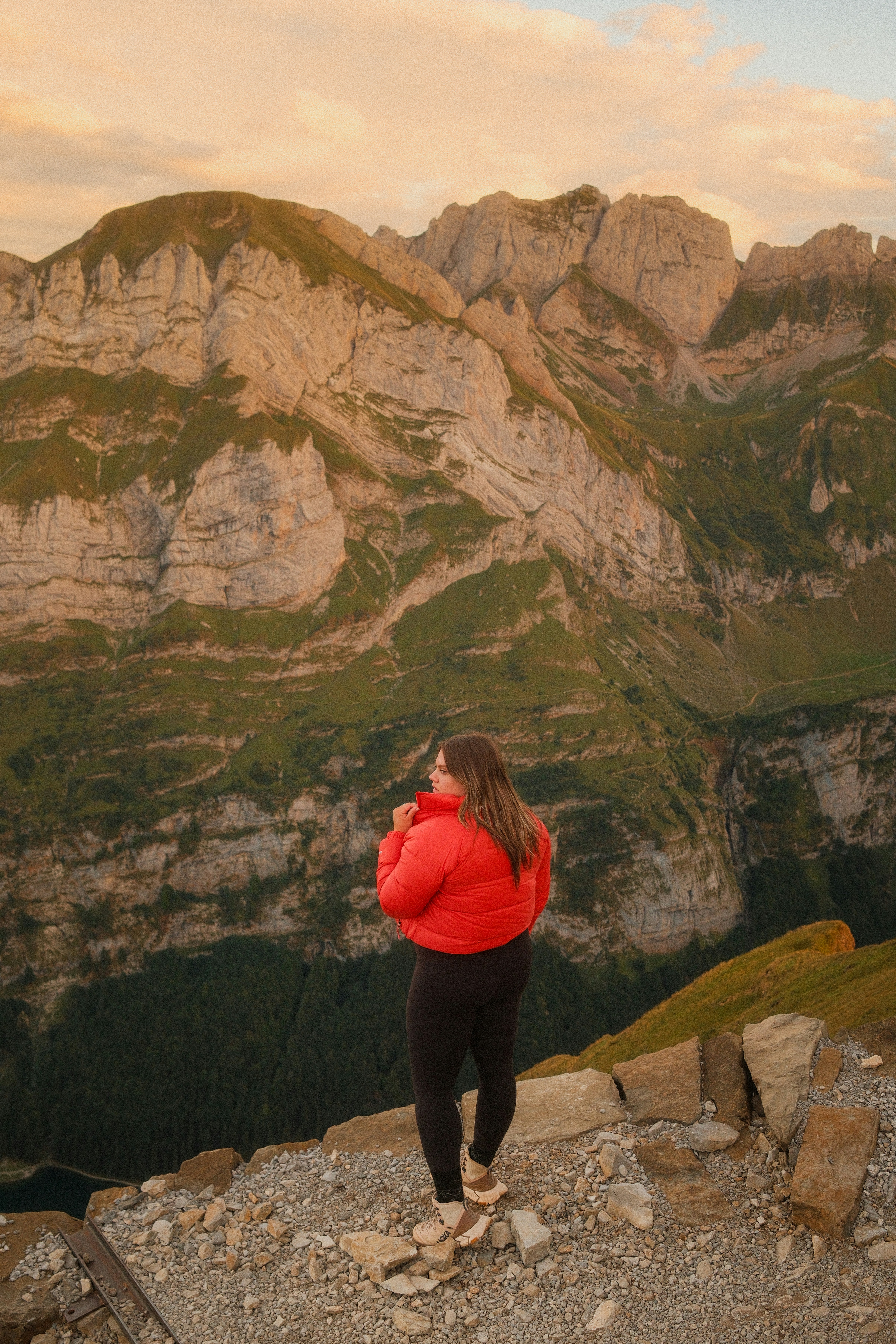 Red Jacket on a Mountain Crest at Sunset