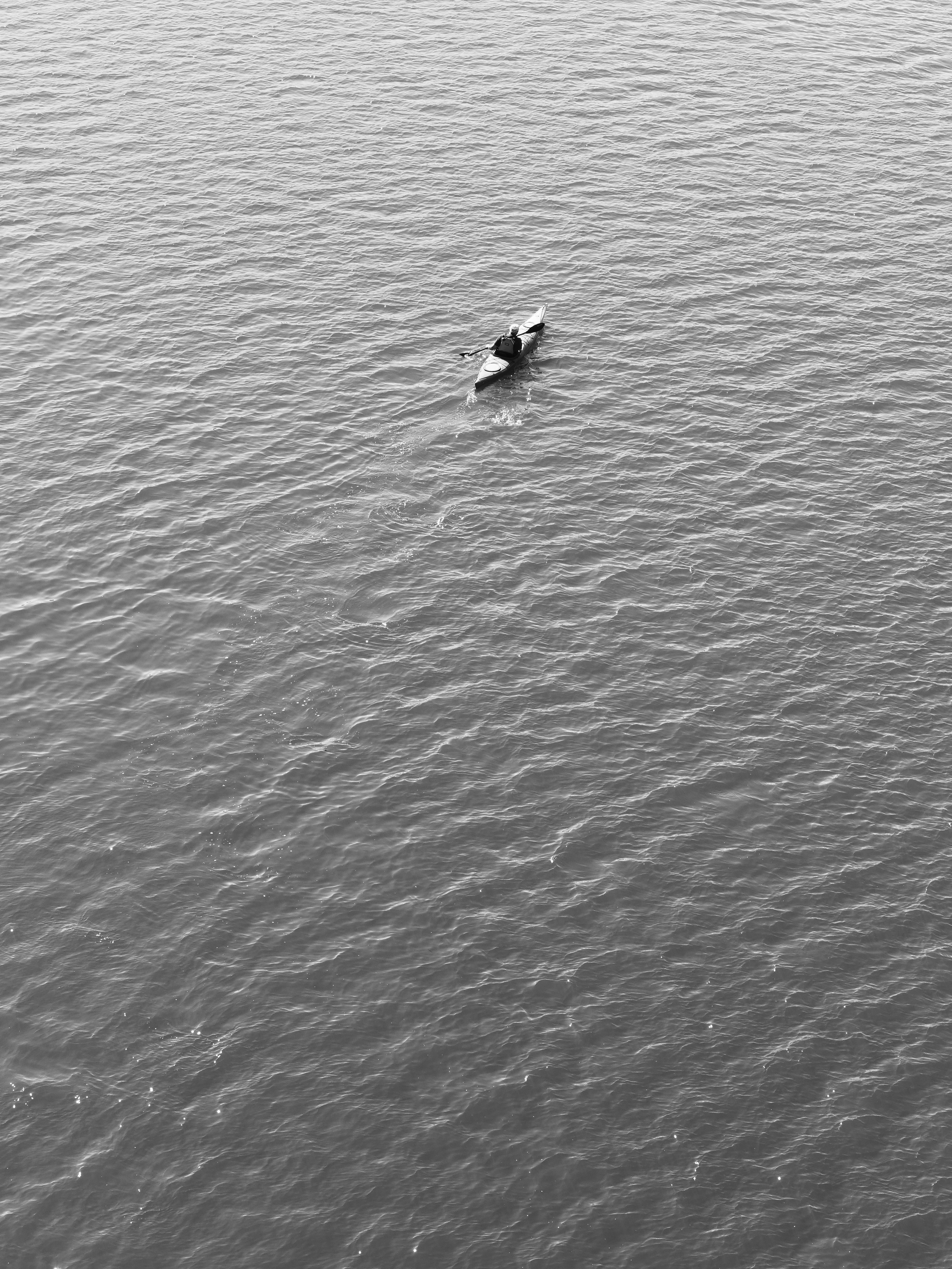 Isolated Rowboat Drifting Across Quiet Grey Seas
