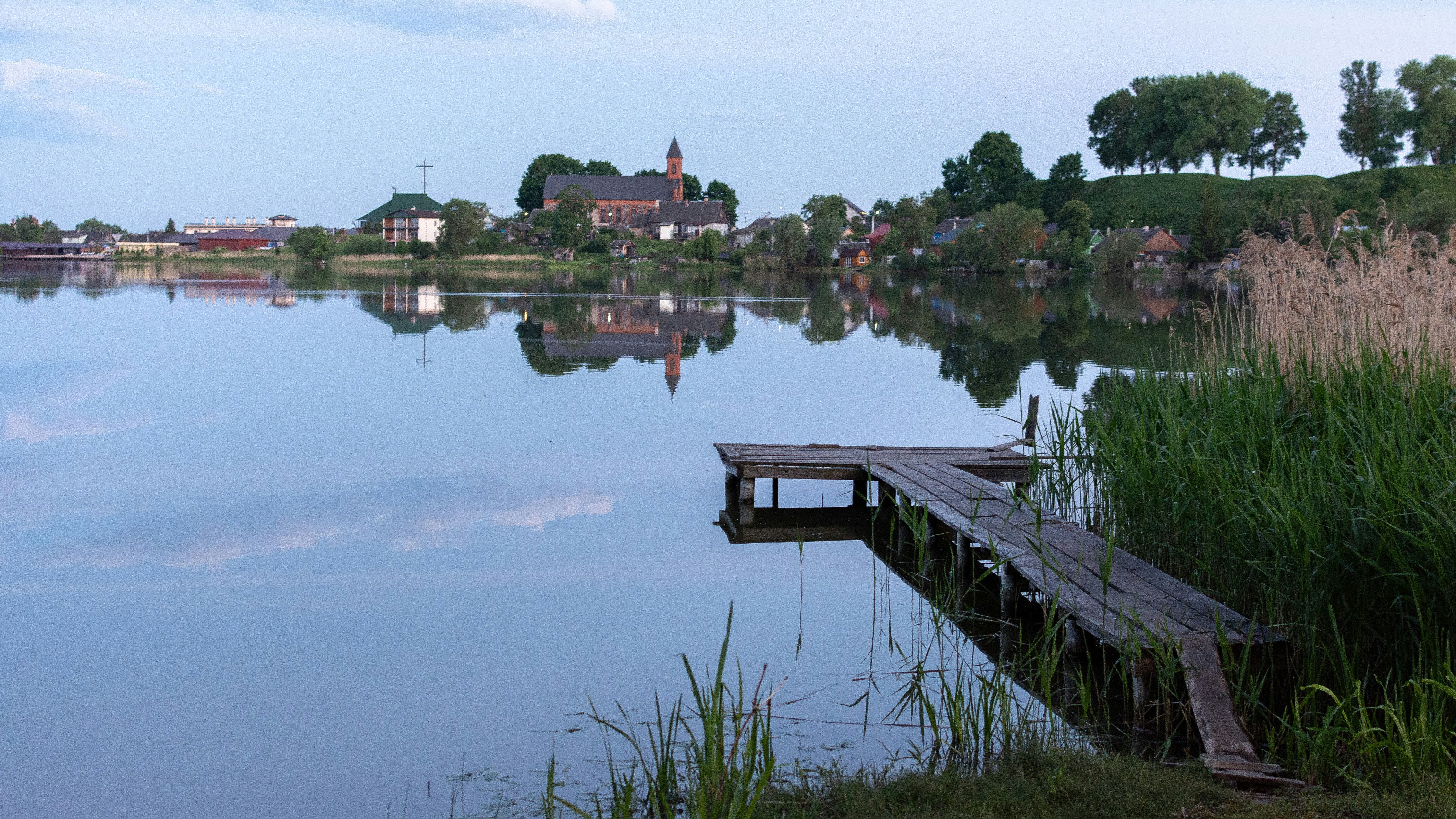 Serene lakeside village dawn with weathered dock