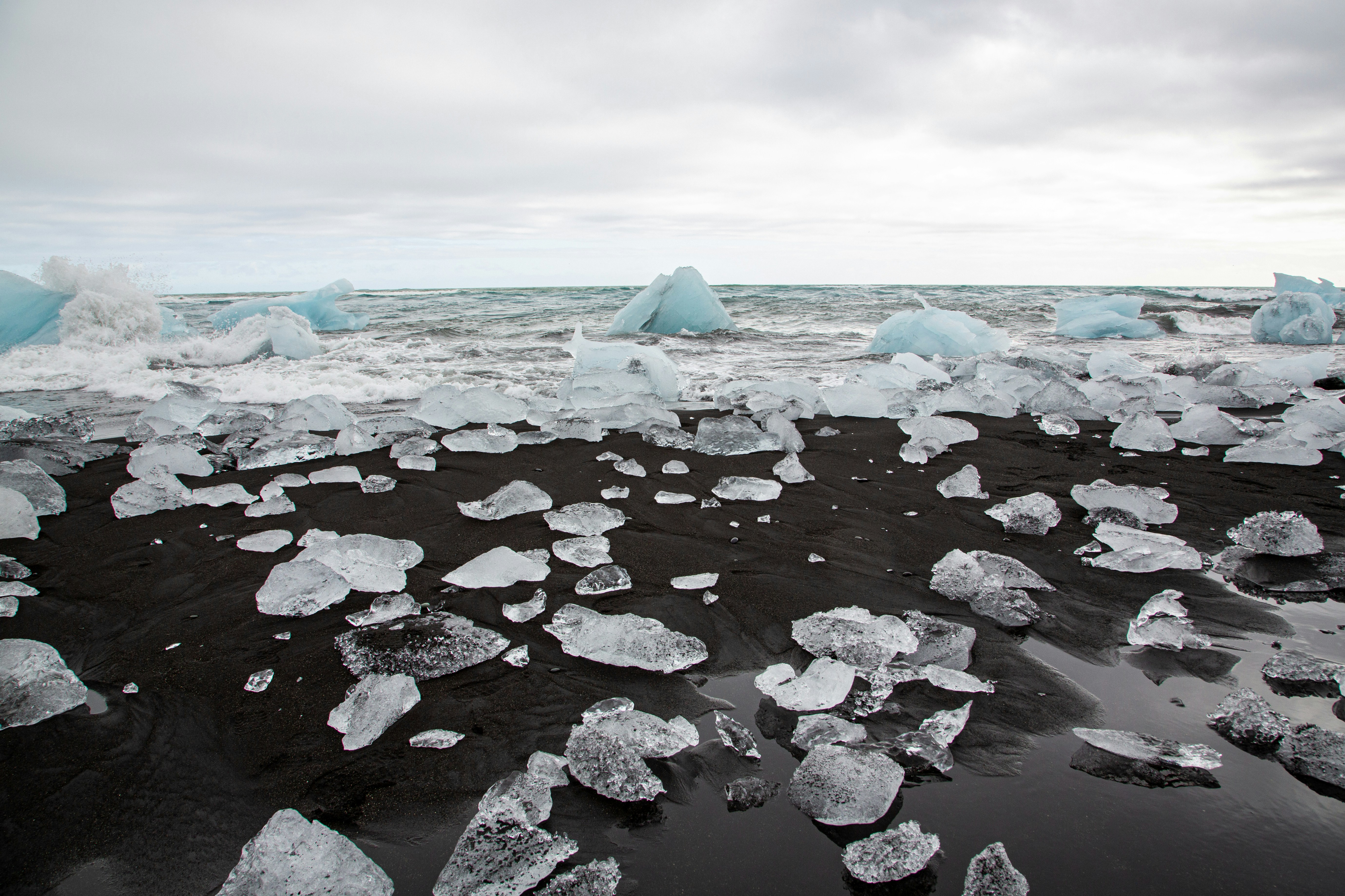 Glacial Shoreline: Ice Fragments on Volcanic Sand at Dusk