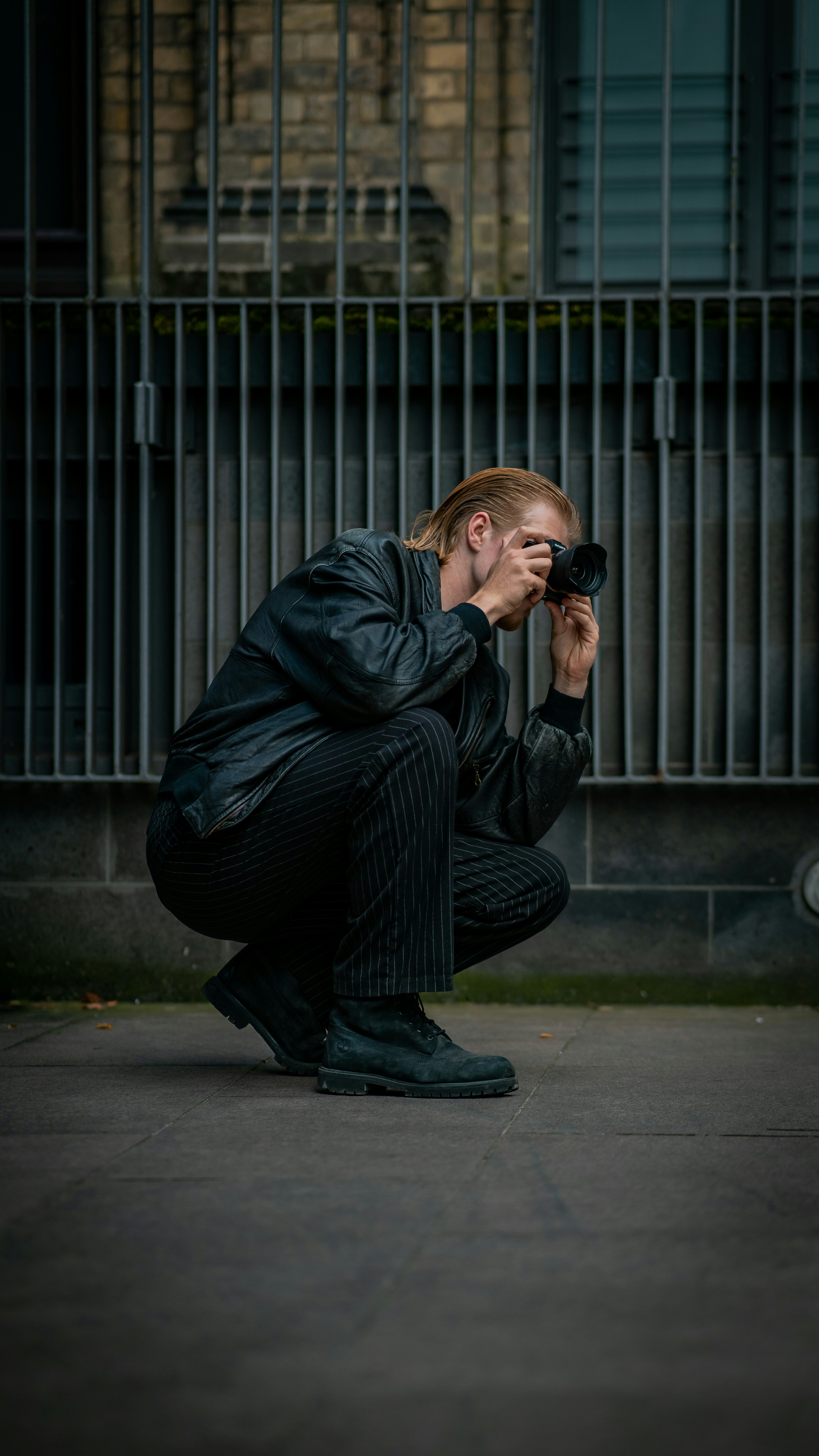 Crouched Photographer Locking Focus Through the Frame