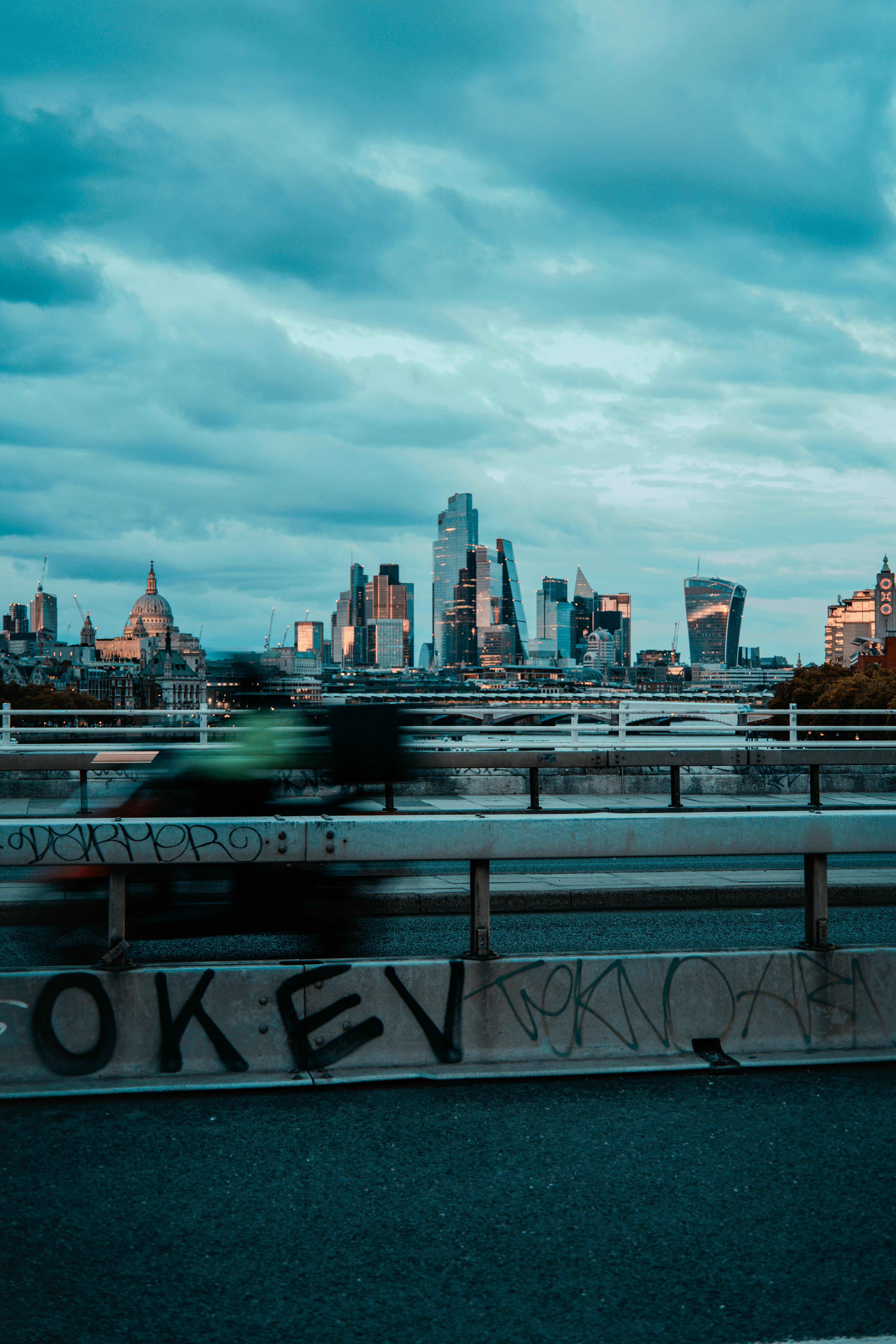 Rush of the Riverfront: Night Skyscrapers Beyond Graffitied Barriers