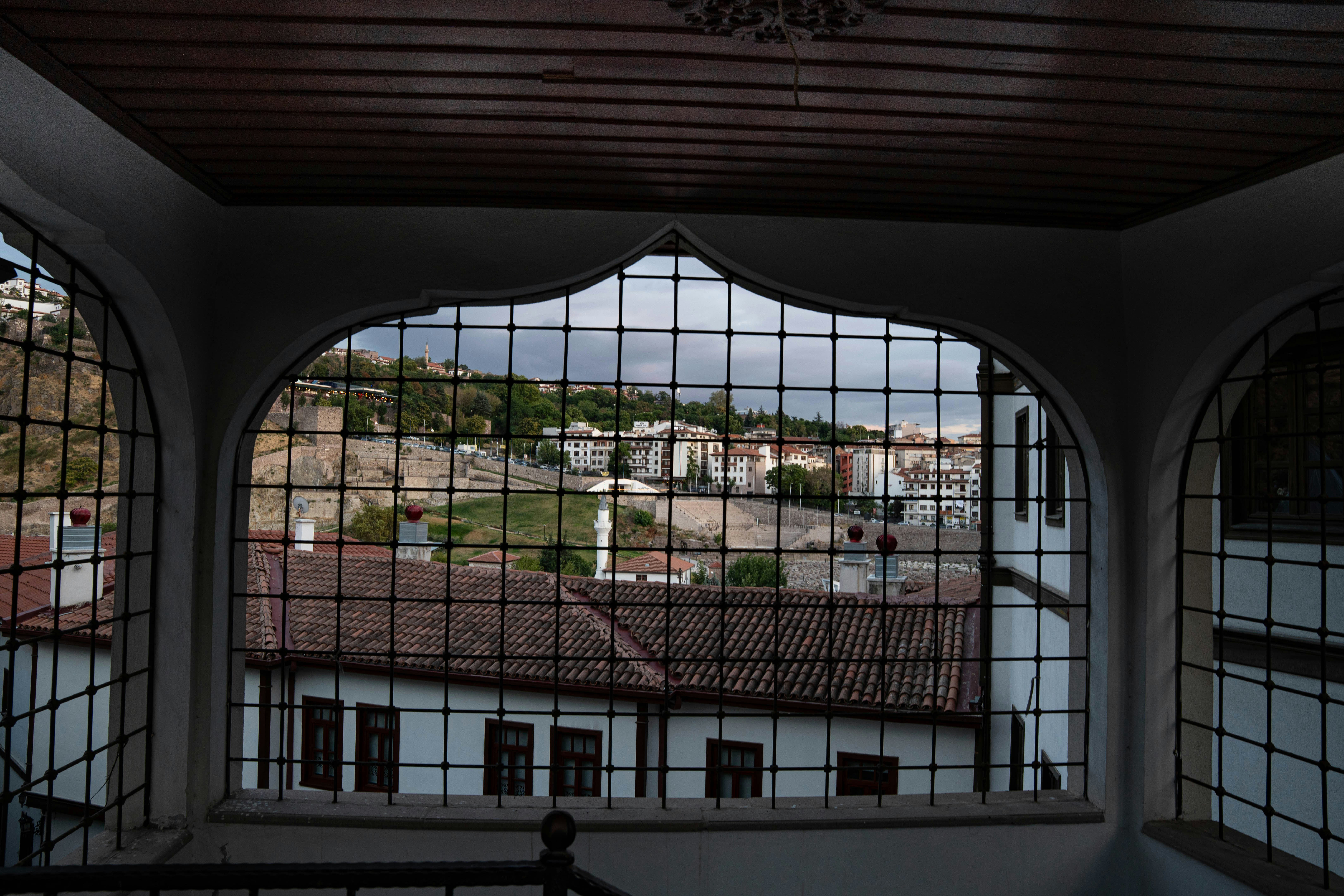 Archway Vista: A City Rooftop Through Wrought-iron Frames