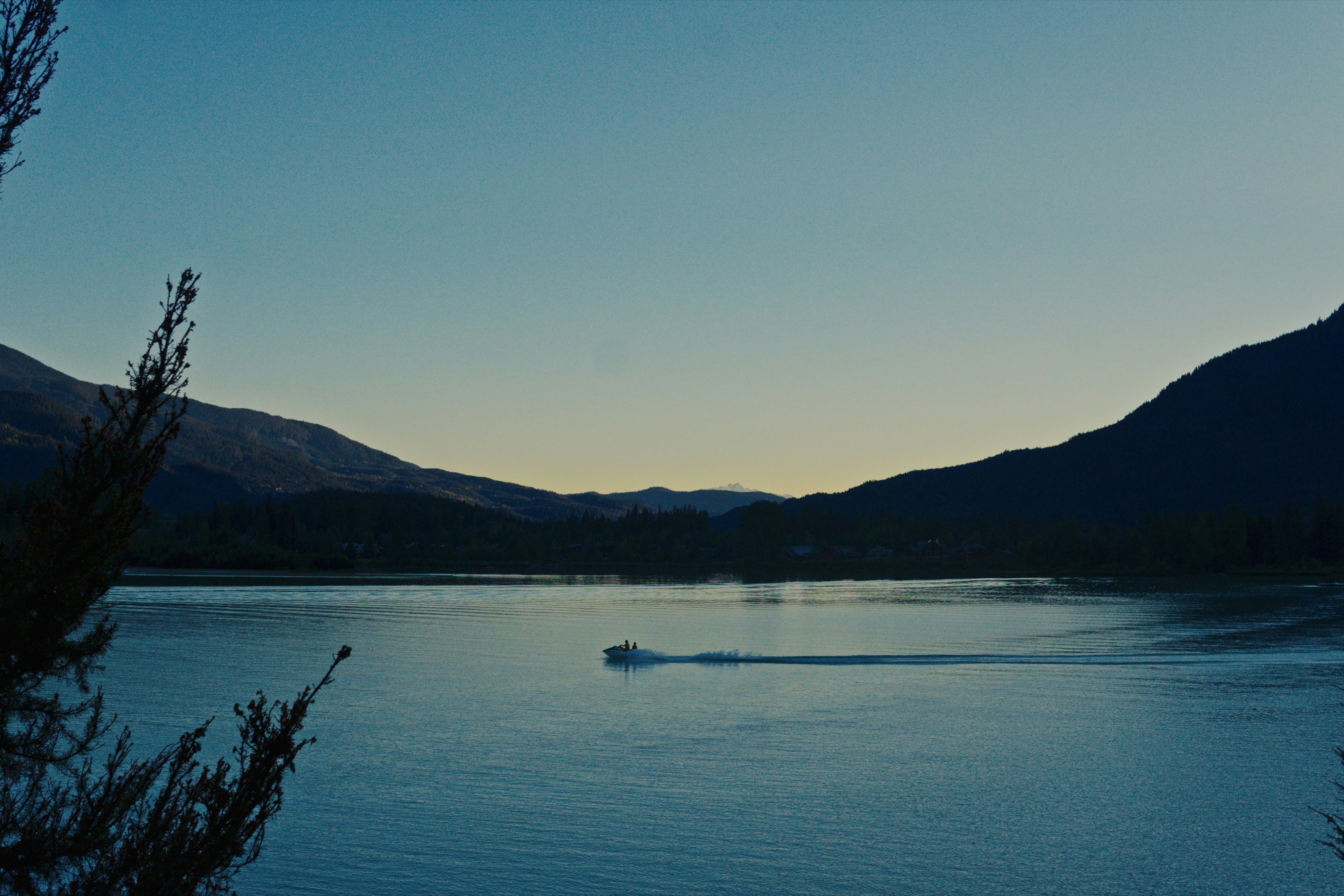 Silent Boat Across a Mountain Lake at Dusk