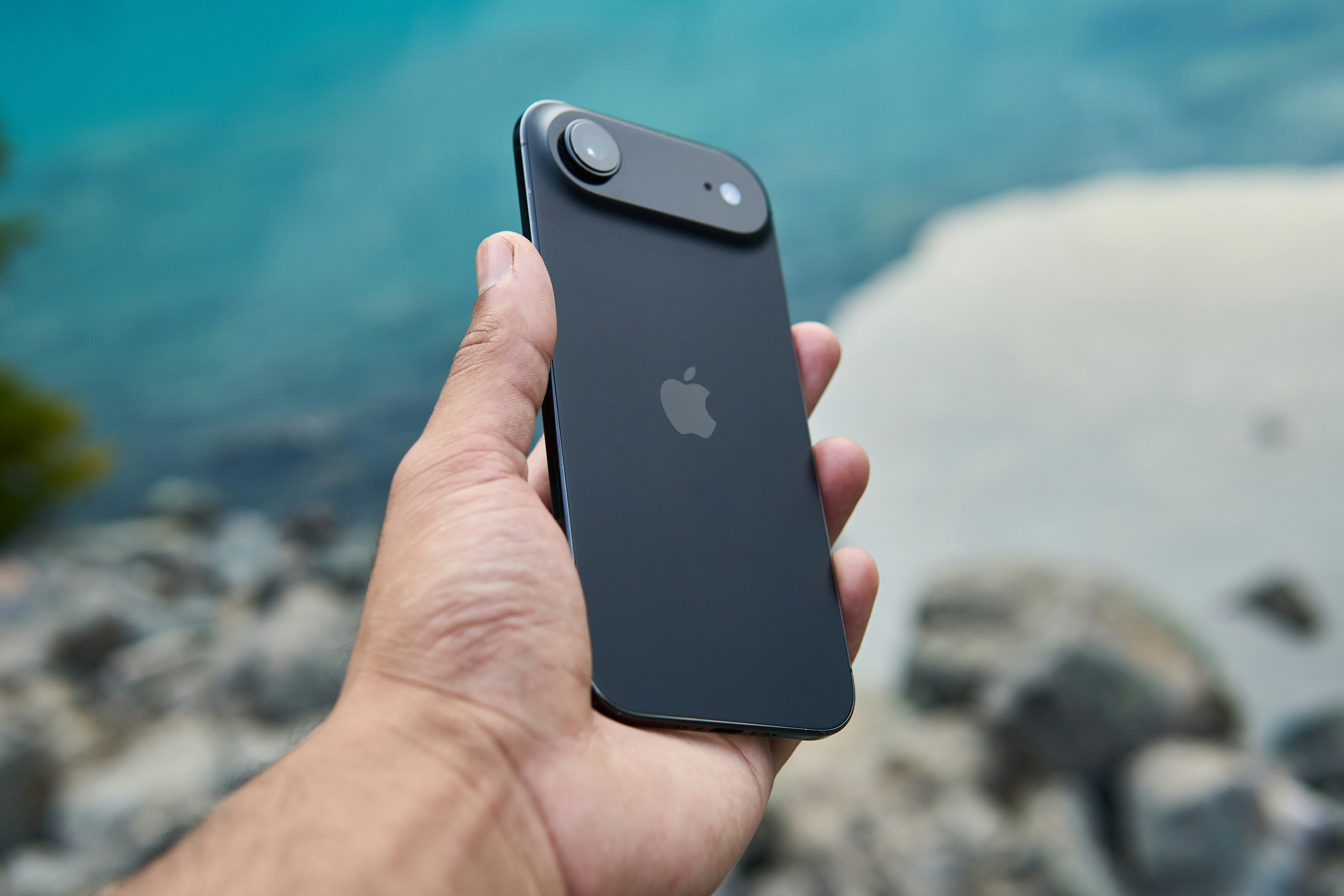 Inhabited by a Monochrome Gadget: A Hand-Held iPhone with Subtle Ocean Backdrop