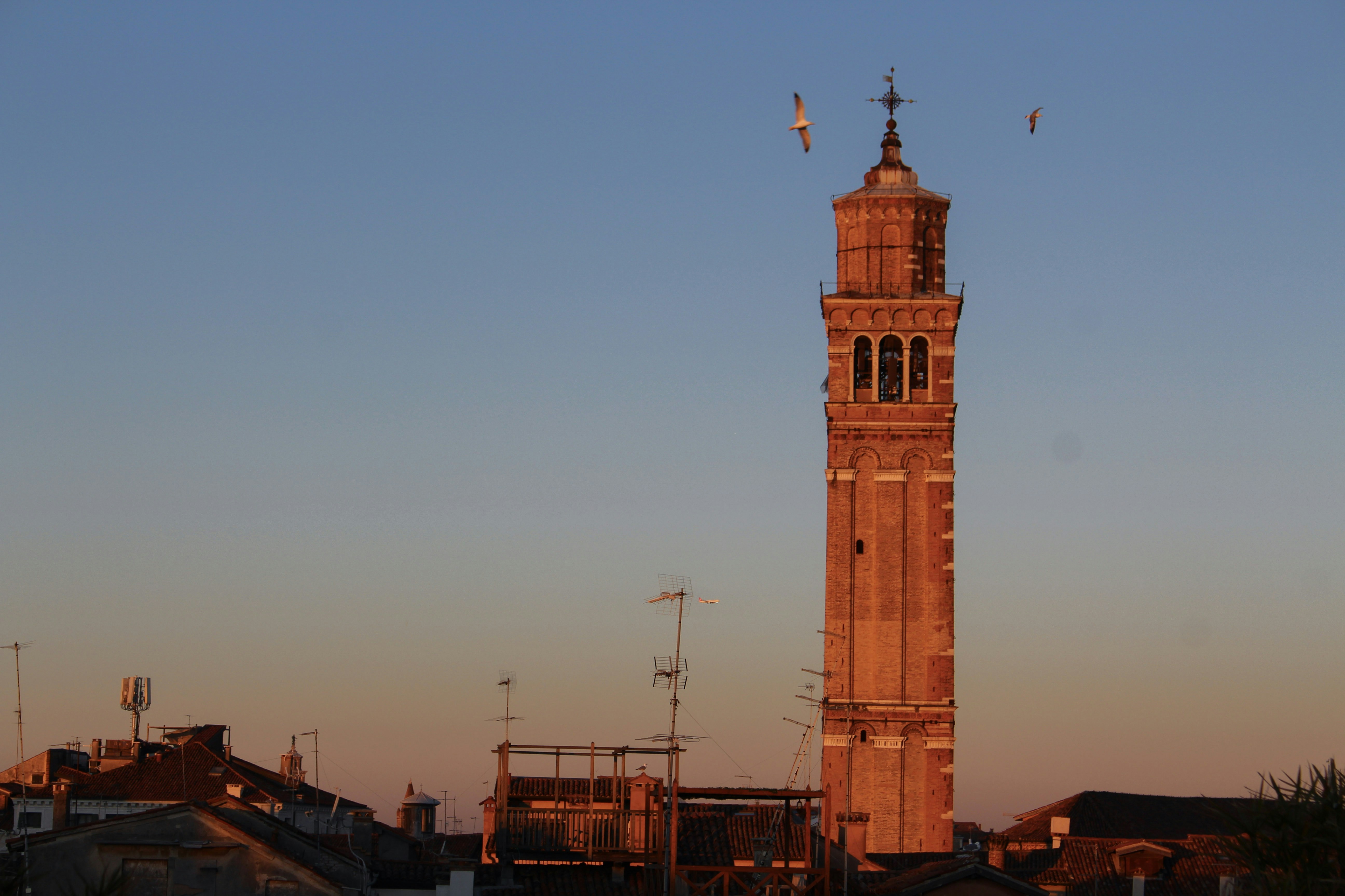 Towering Sunset Beacon Over a Quiet Rooftop Cityscape
