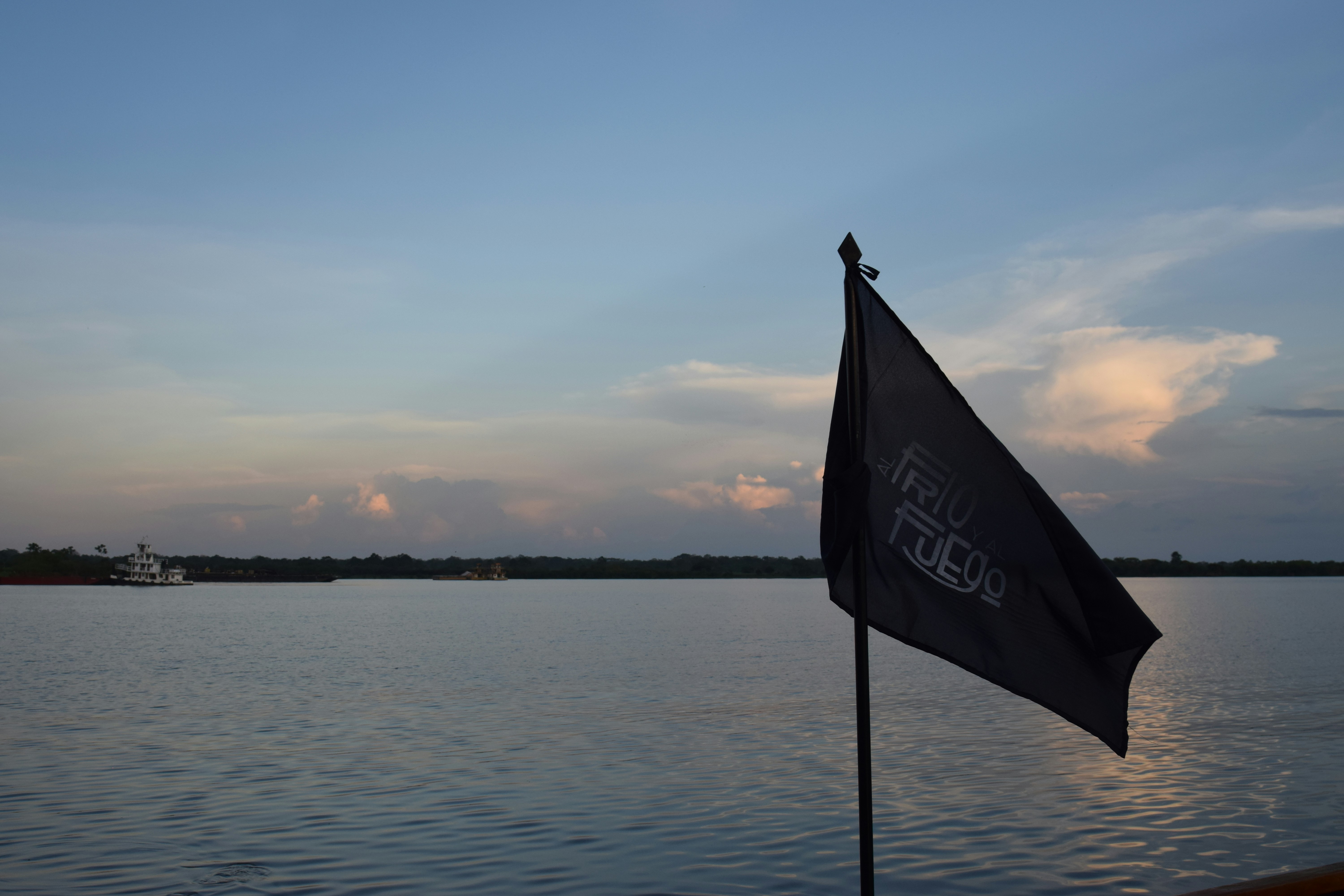Flag at Dusk Over Calm River