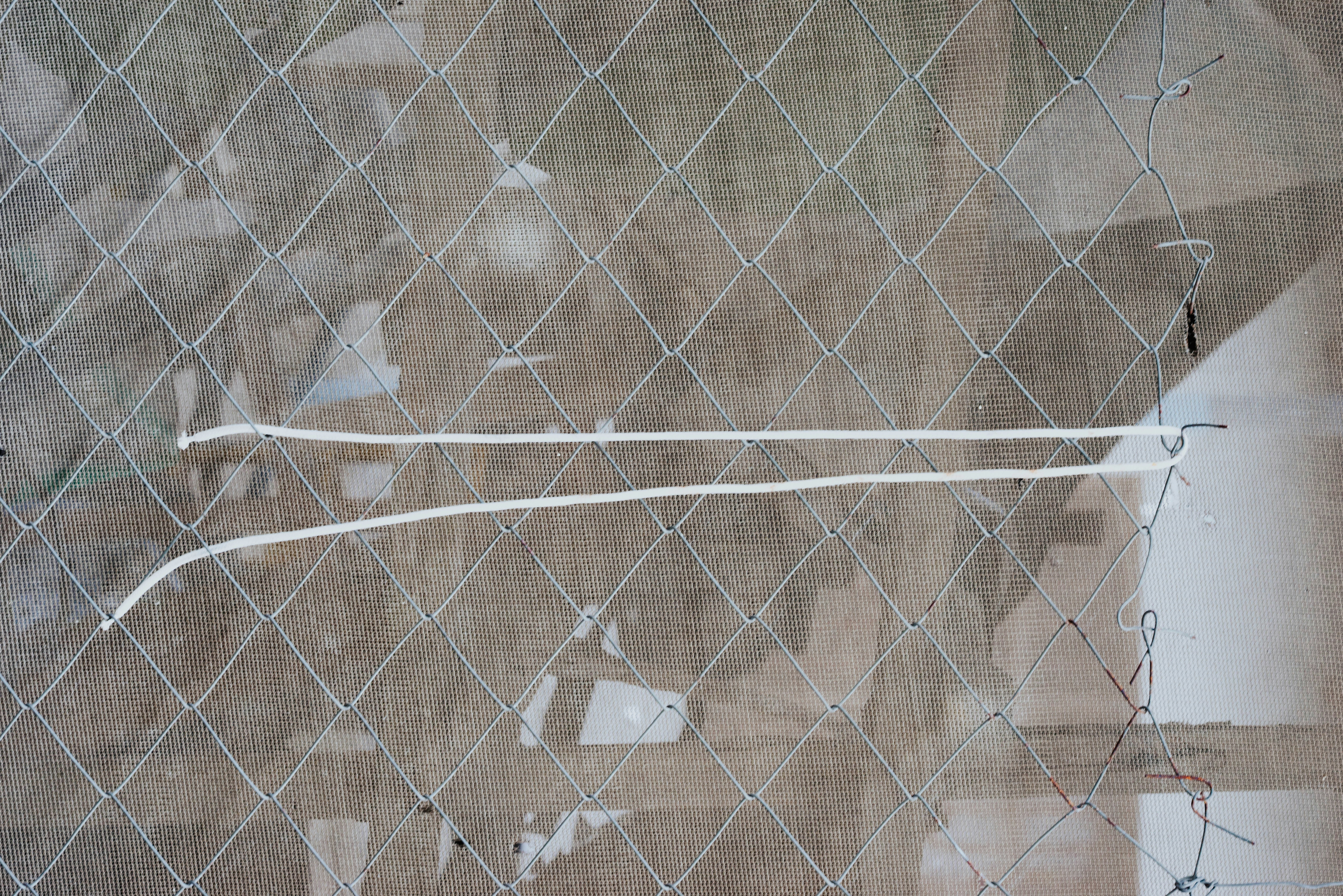 Frayed Network: A Close Look at Mesh and Tape on a Weathered Surface