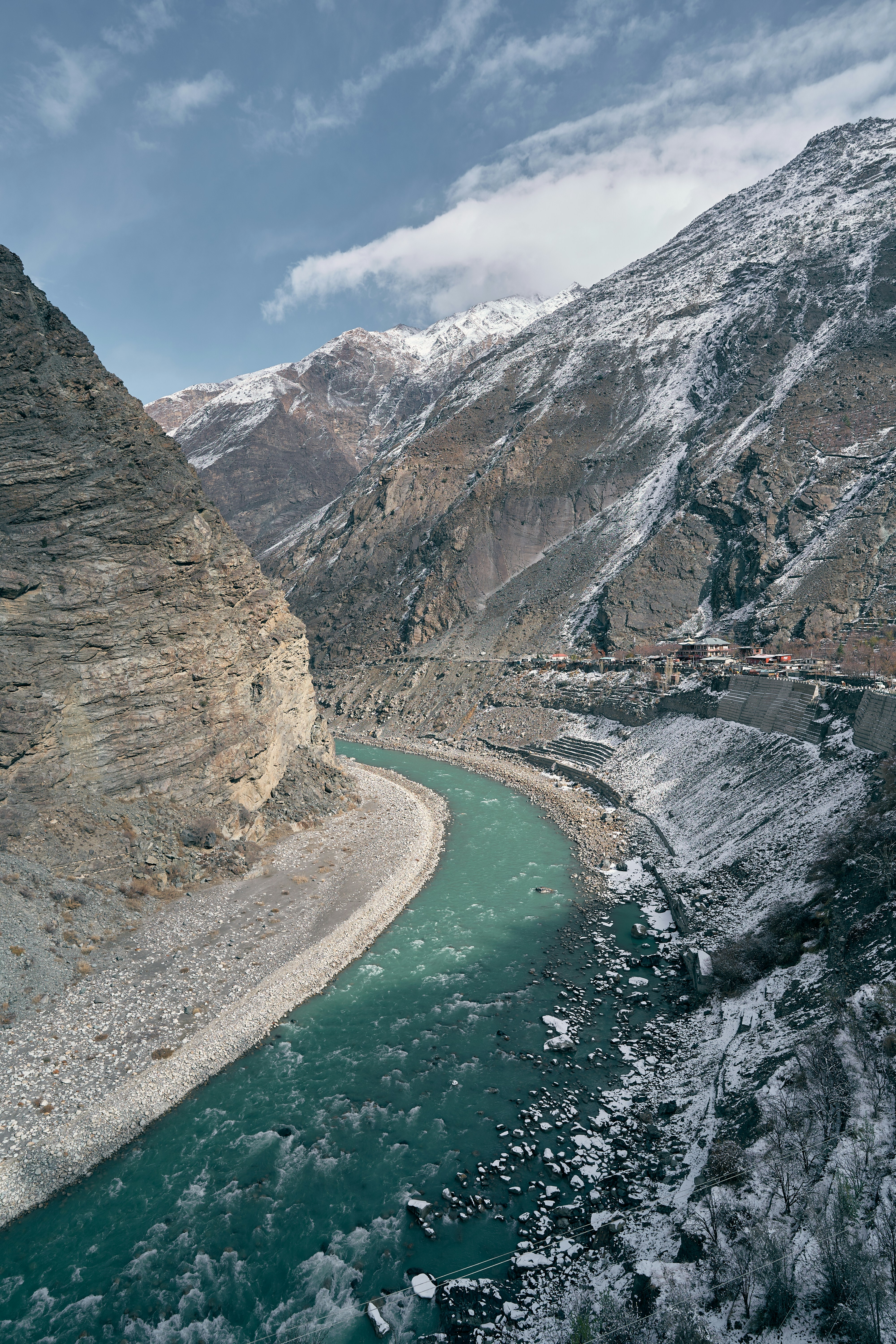 Rugged Gorge Confluence: Turquoise River Winding Through Snow-Trimmed Peaks