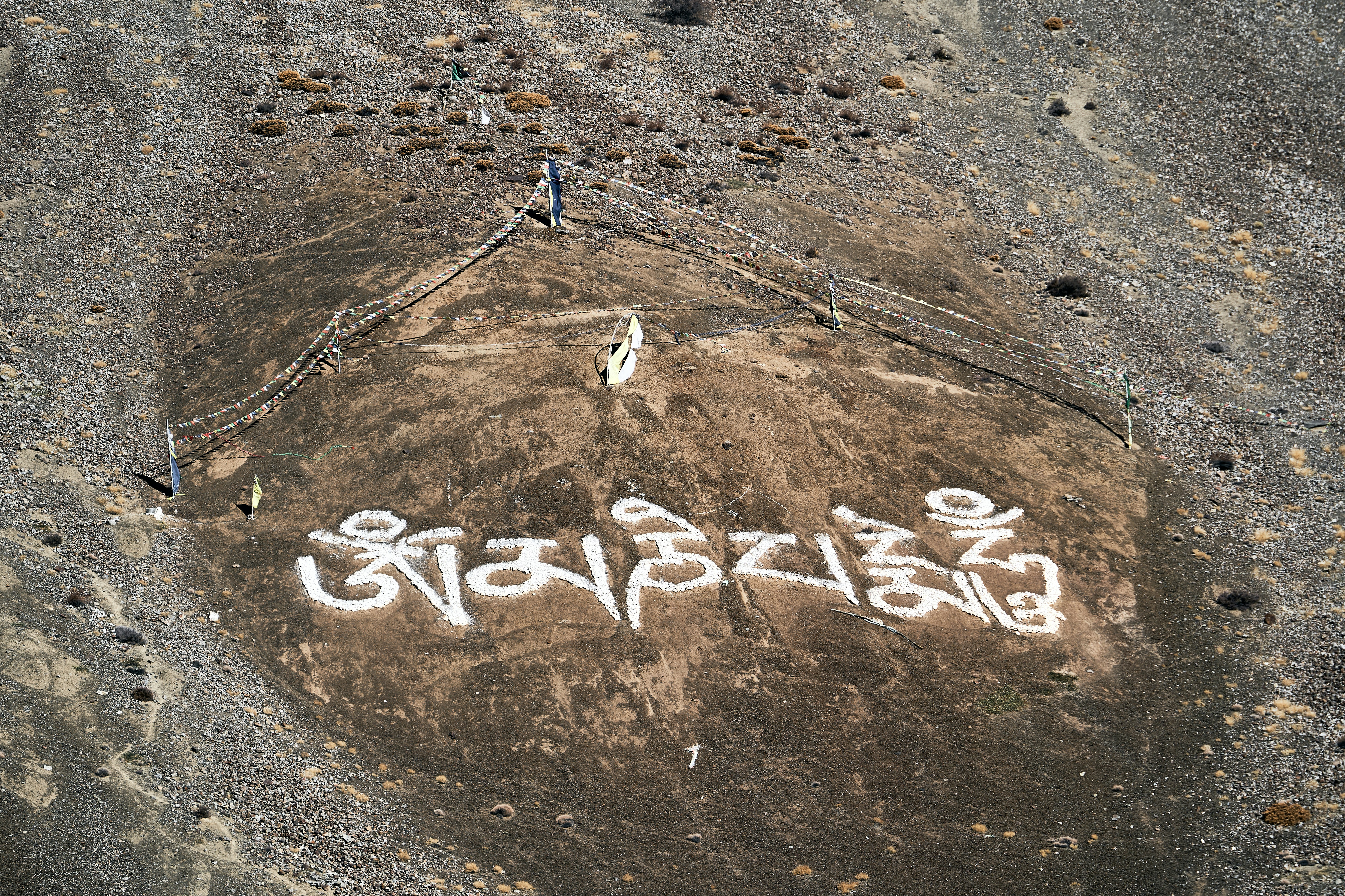 Sacred Ground: An Aerial View of Hand-Painted Mantra on a Raised Terrace
