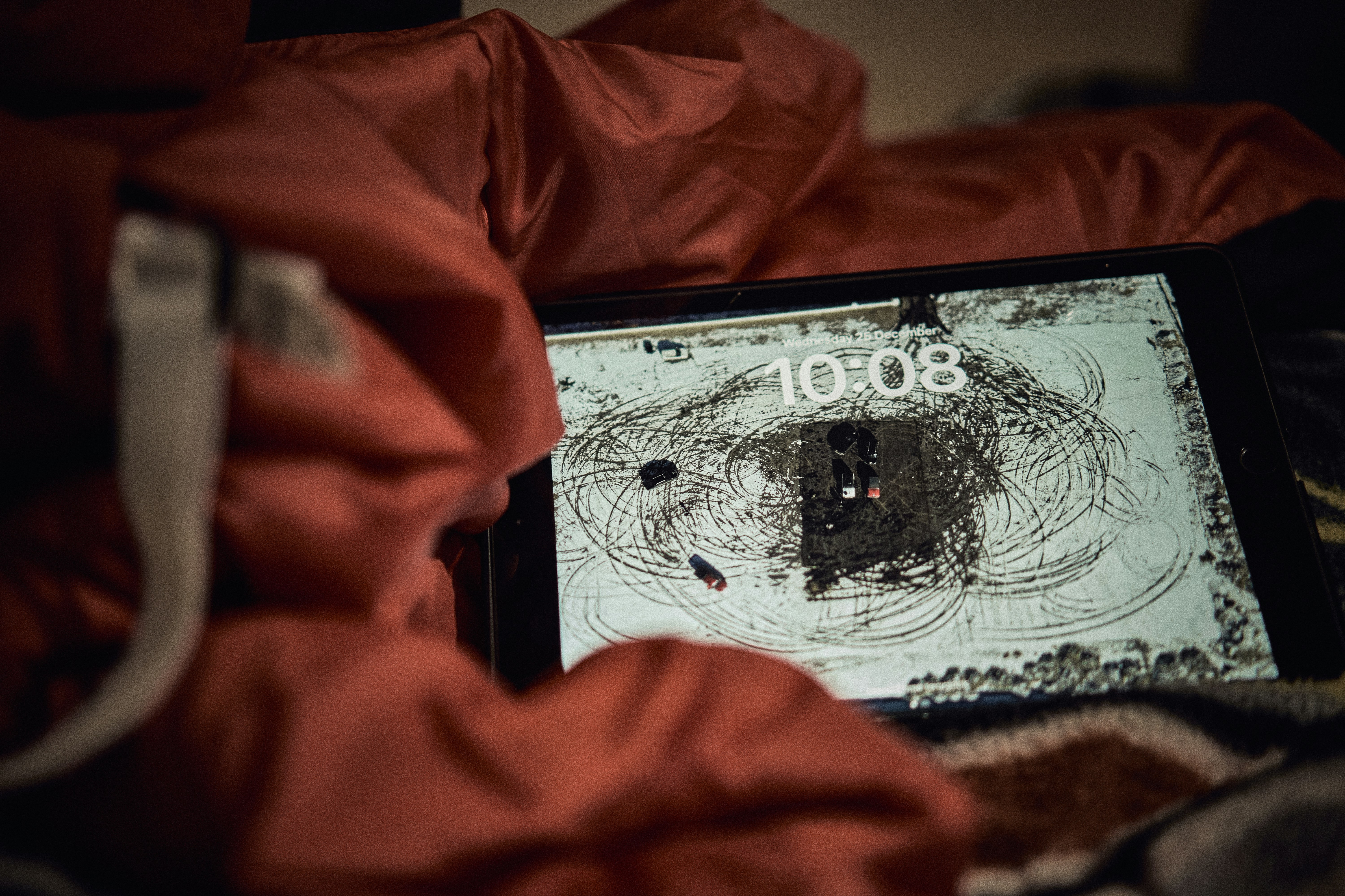 Stitched Constellation on a Screen: A Tablet Amid Crumpled Fabric