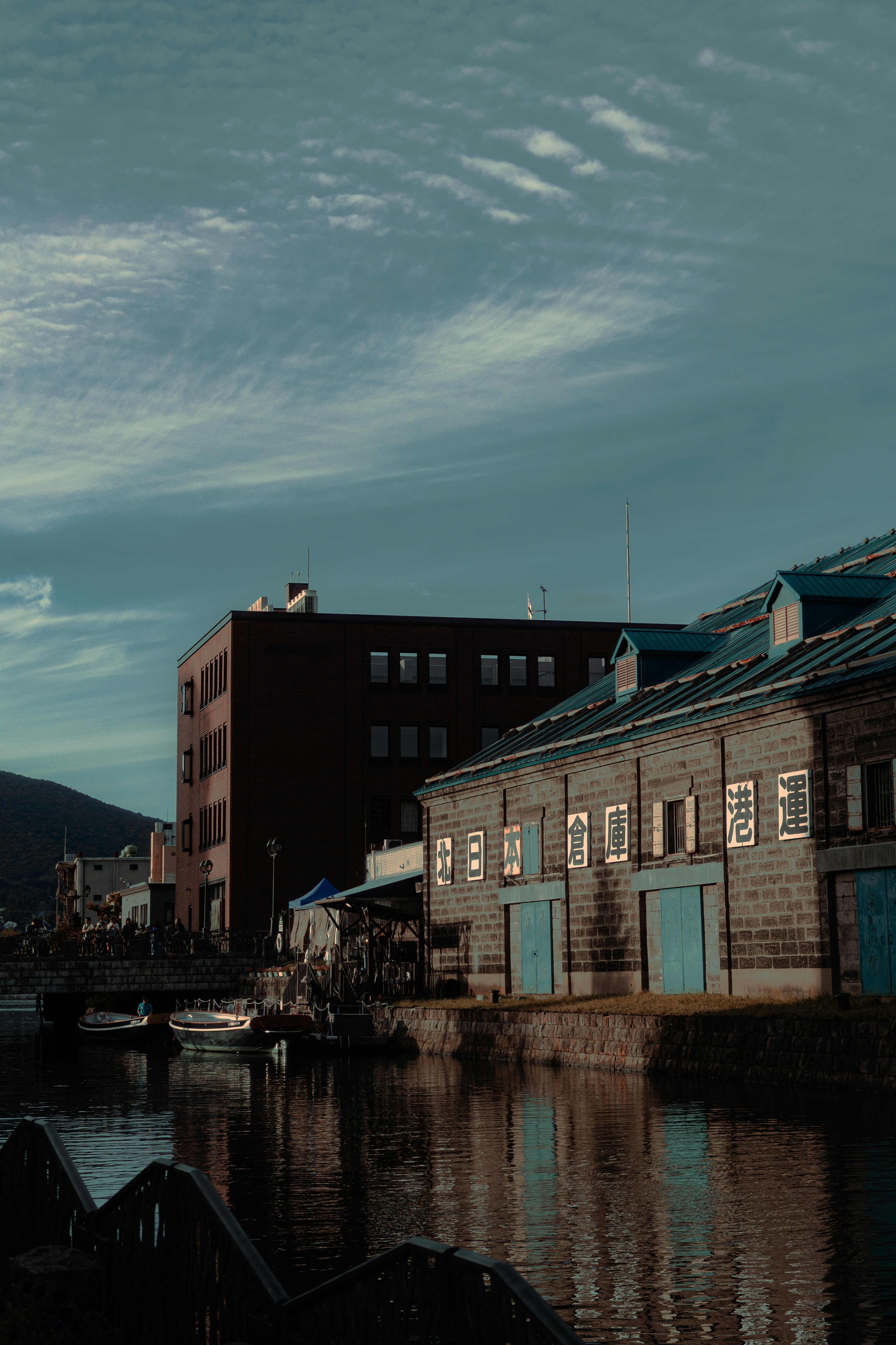 Harborfront Warehouse: Weathered Facades Reflect in Narrow Channel