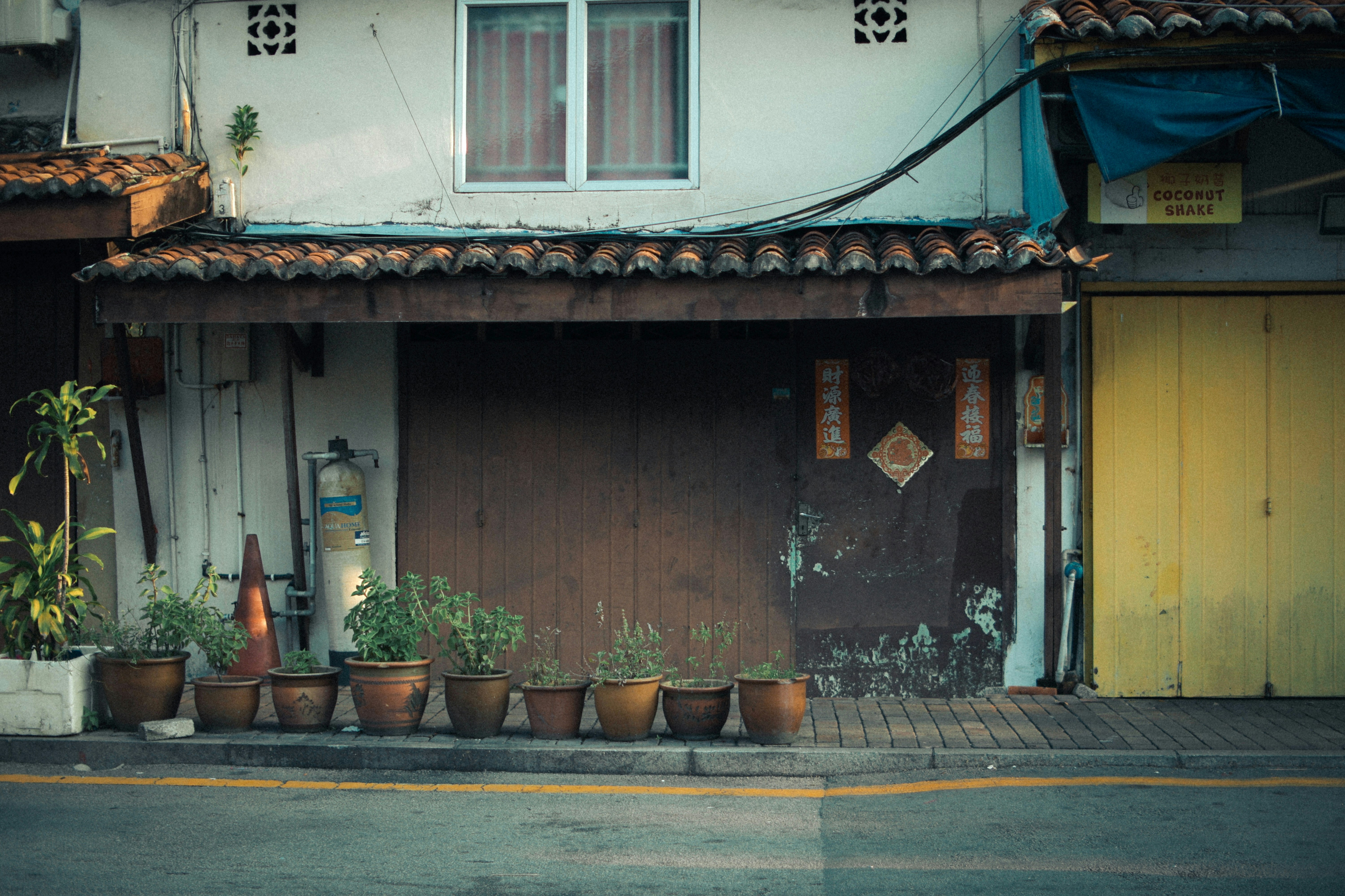 Clay Pots and Closed Shopfront: A Quiet Street Scene in Warm Light