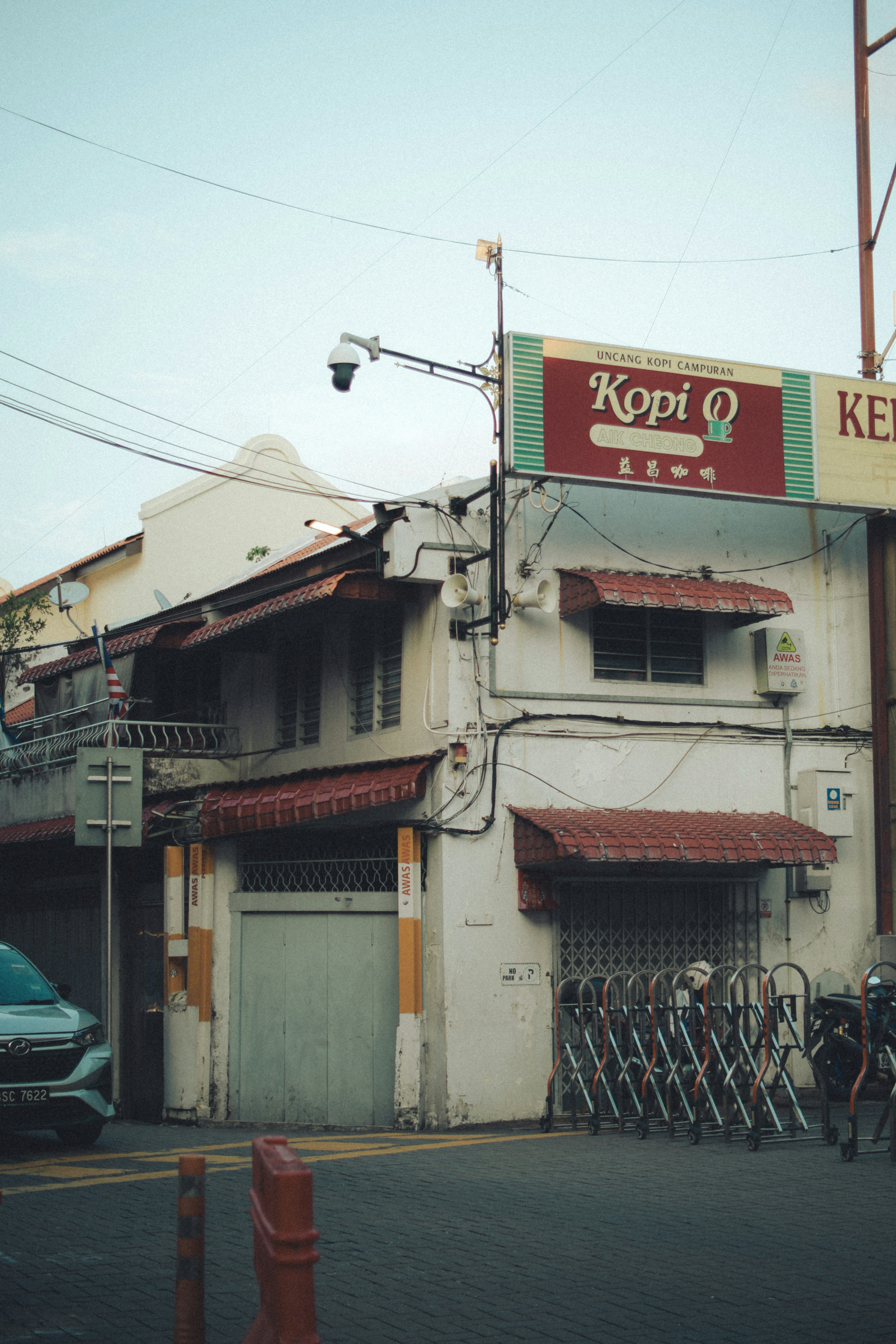 Kopitiam Corner: A Quiet Street with Bicycles and Shaded Facades