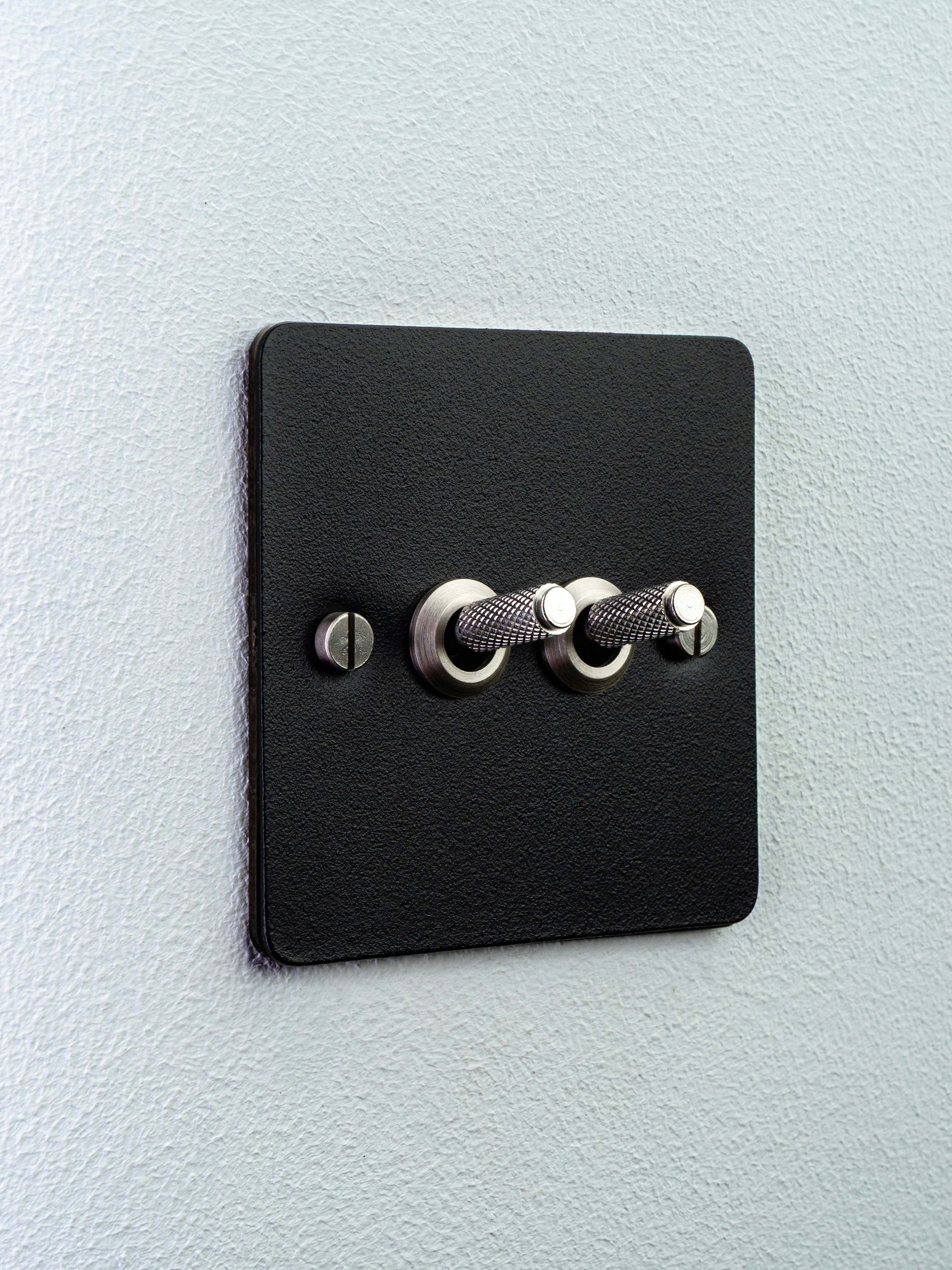 Industrial Quiet: A Close-Up on the Wall Plate and Knurled Toggle