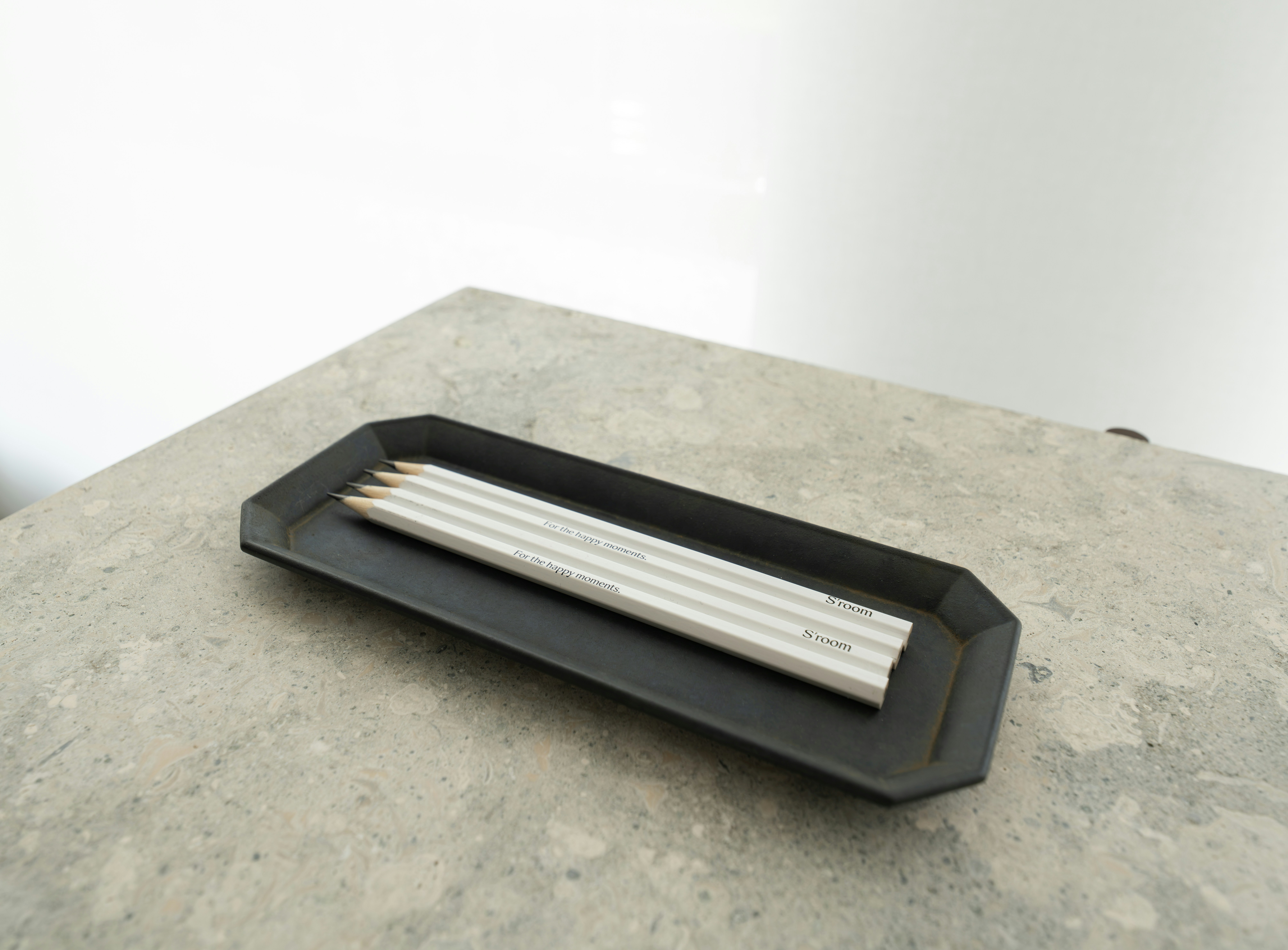 A Quiet Tray of Pencils on a Concrete Workbench