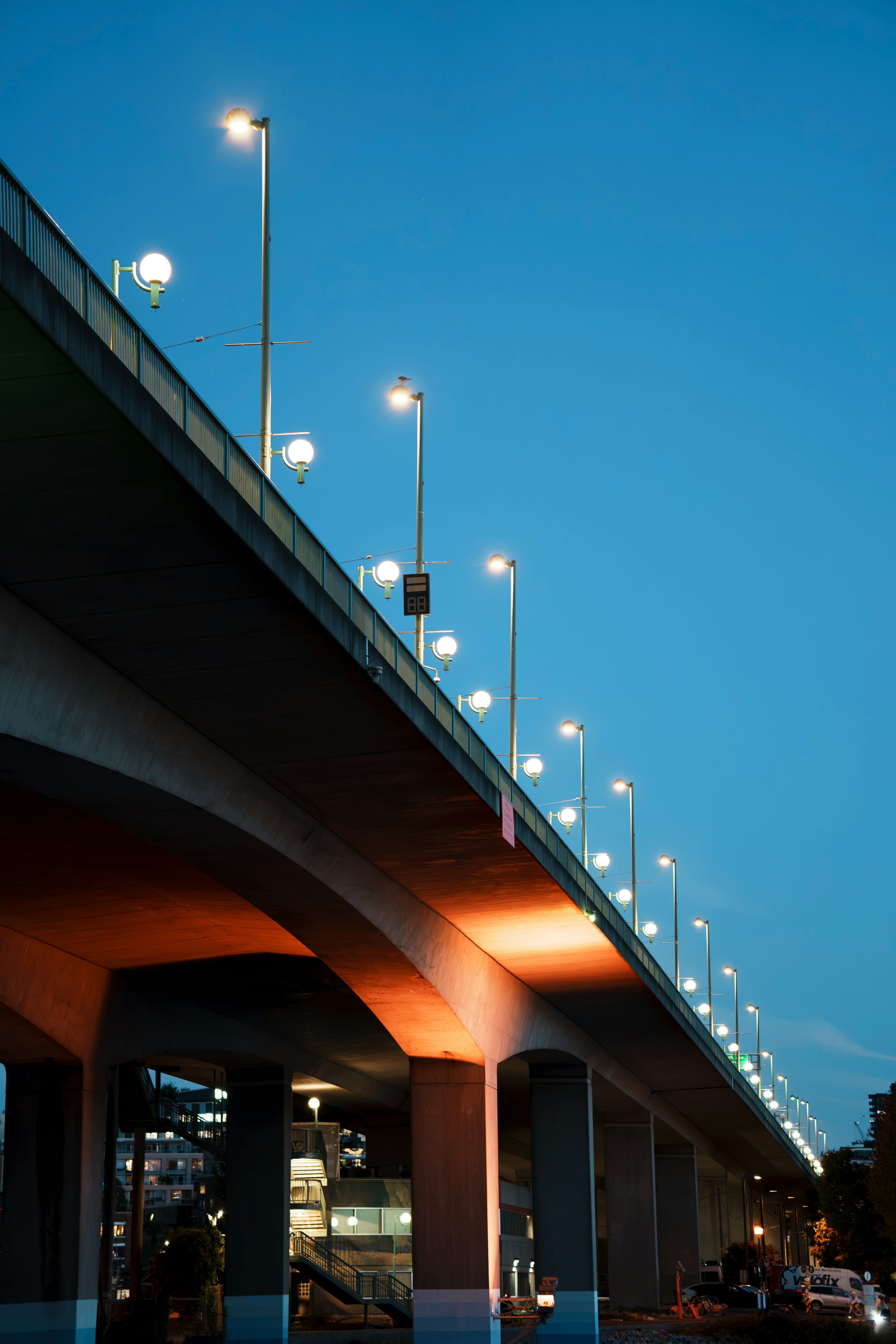 Under the Blue Span: Evening Streetlight Corridor on an Elevated Road