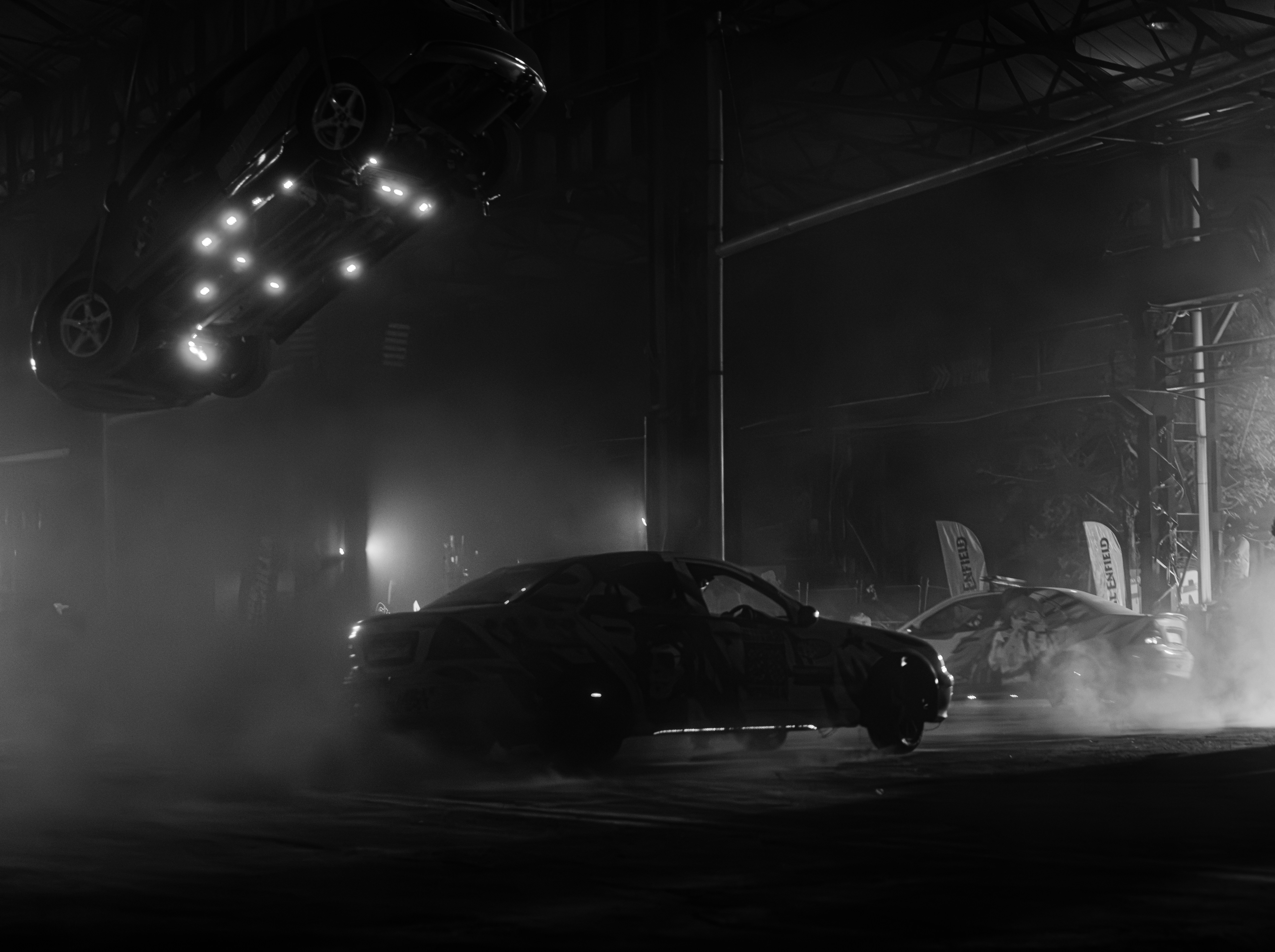 Rally of Smoke and Steel: Night Show car lift beneath a drifting chandelier of lights