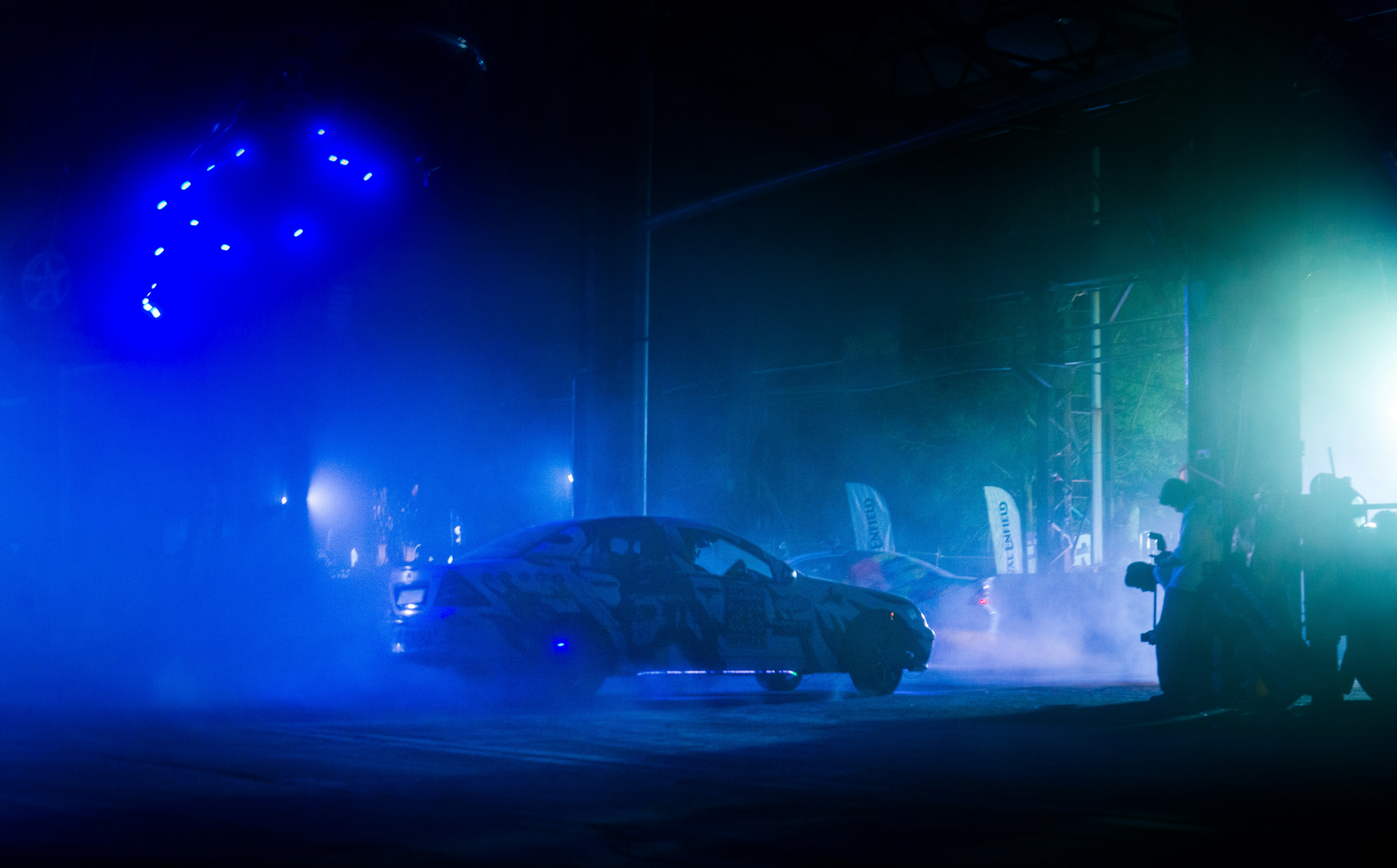Blue-lit Drift: Neon Smoke Encircles a Silhouette of a Car