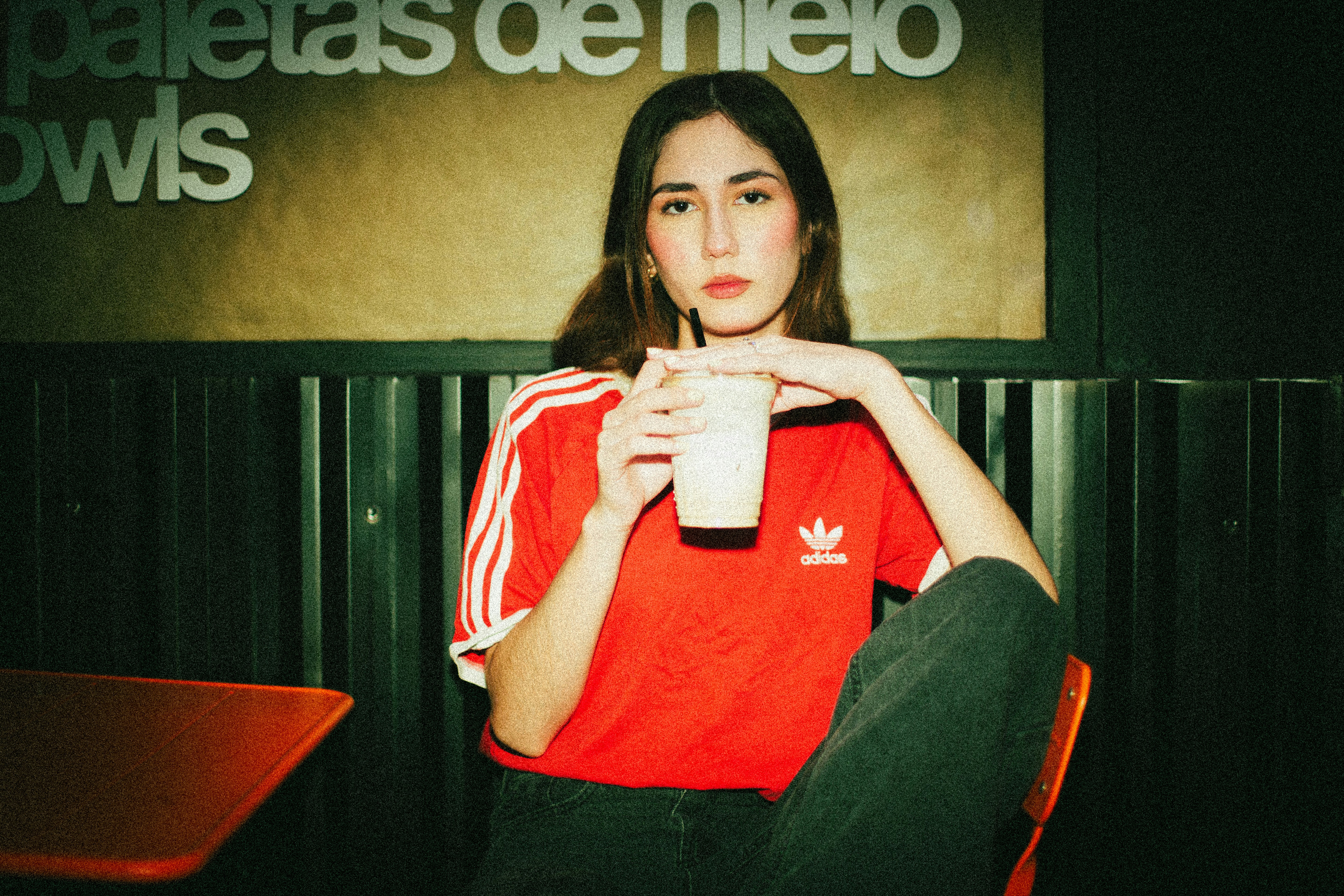 Red-cup Caliber: A relaxed cafe moment with a casual Adidas red tee