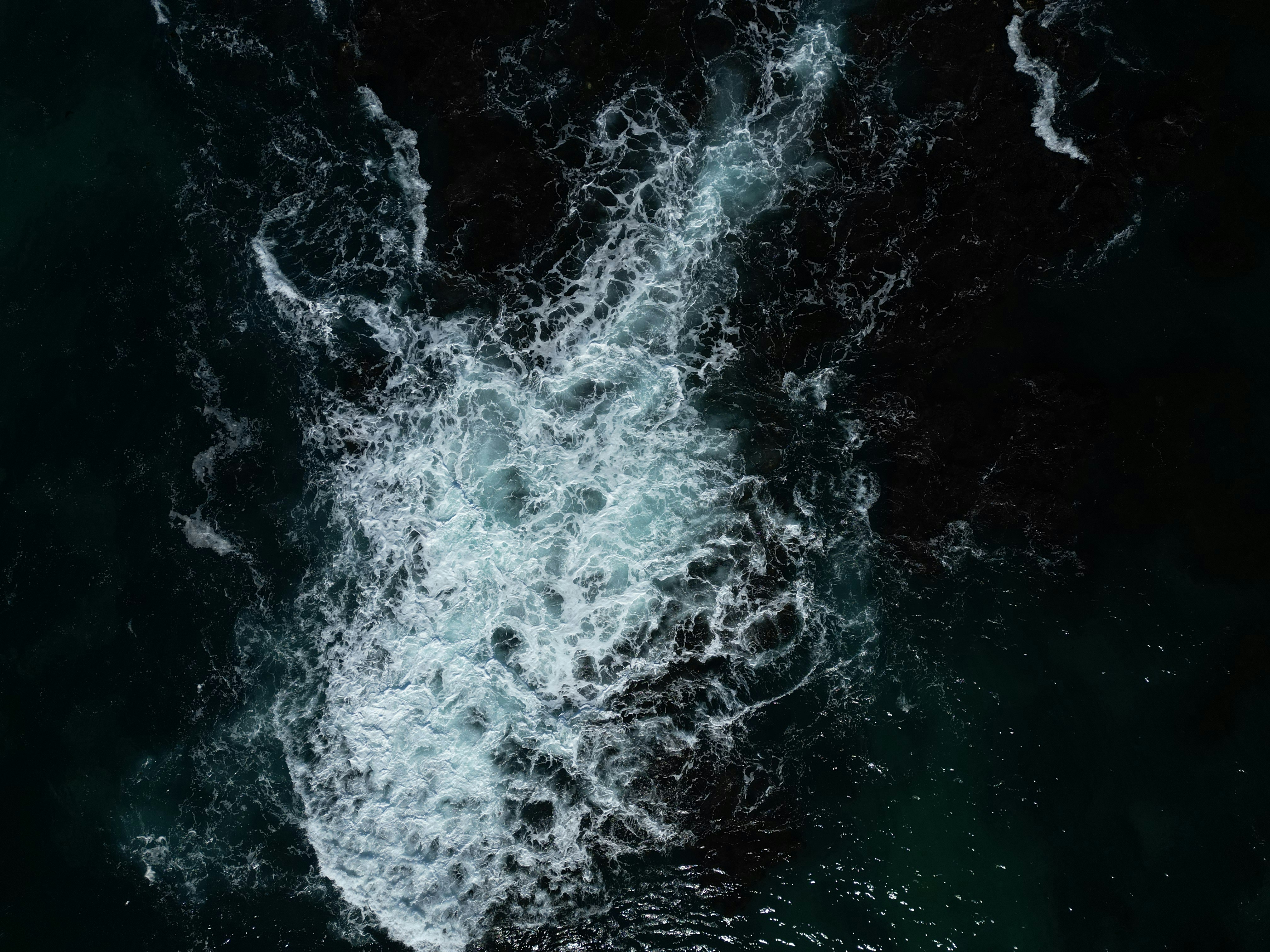 White-foam current carving through midnight blue sea