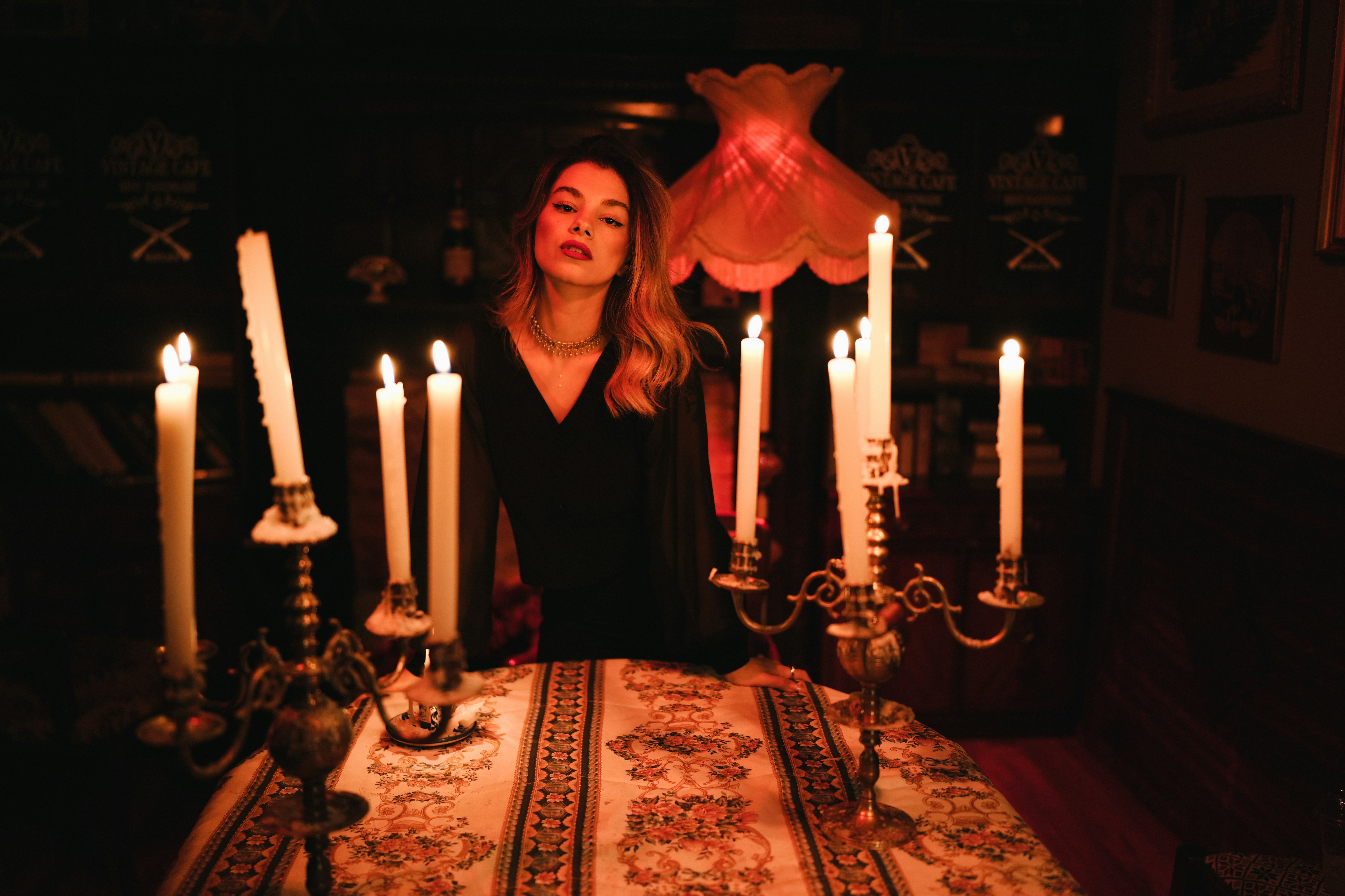 Silent Centerpiece: A Woman Amid Candlelit Tapestry