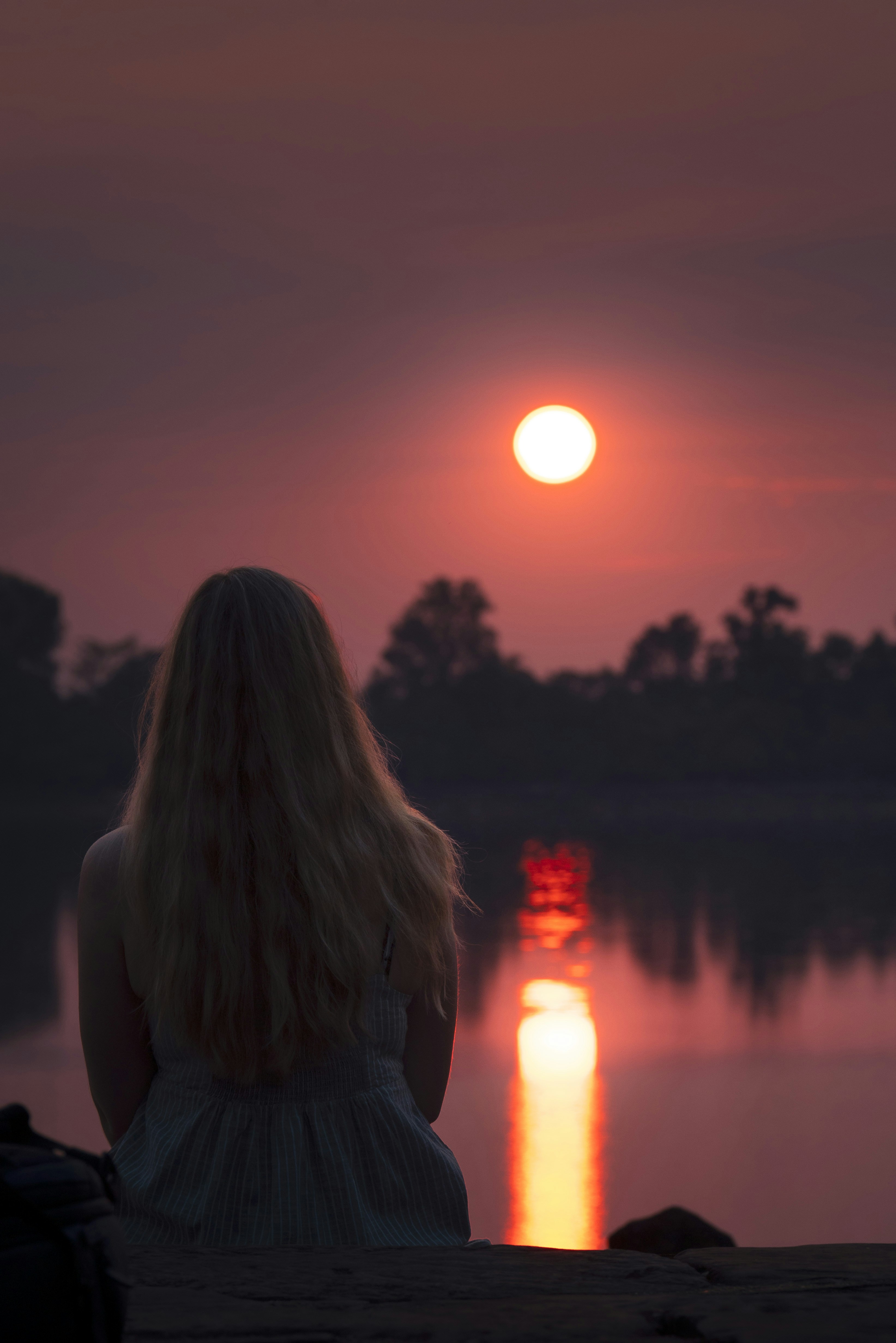 Sunset Reverie: A Silhouette Watches the Evening Fire on the Water