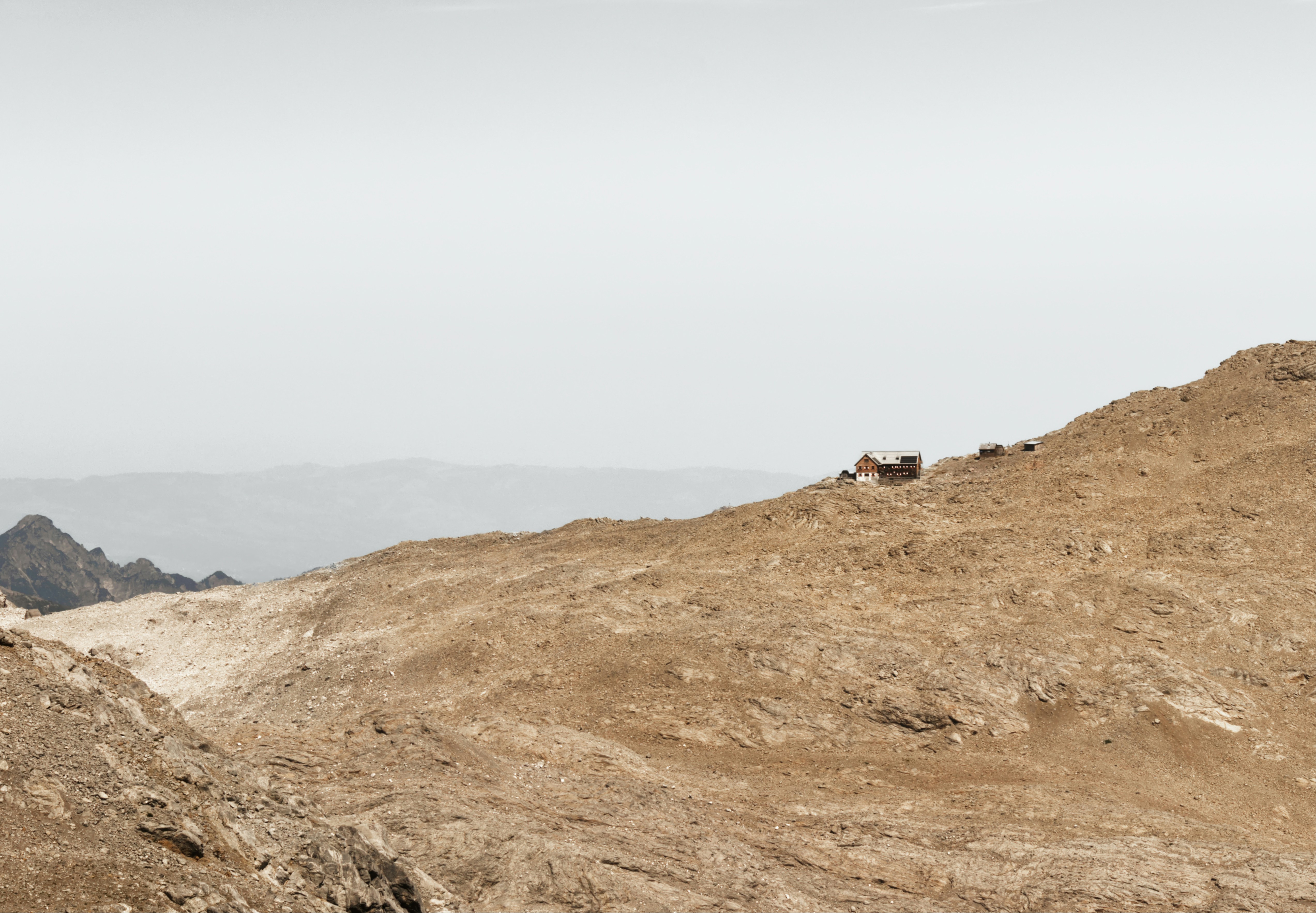 A Remote Jeep Clings to a Windswept Ridge Above the Desert Expanse