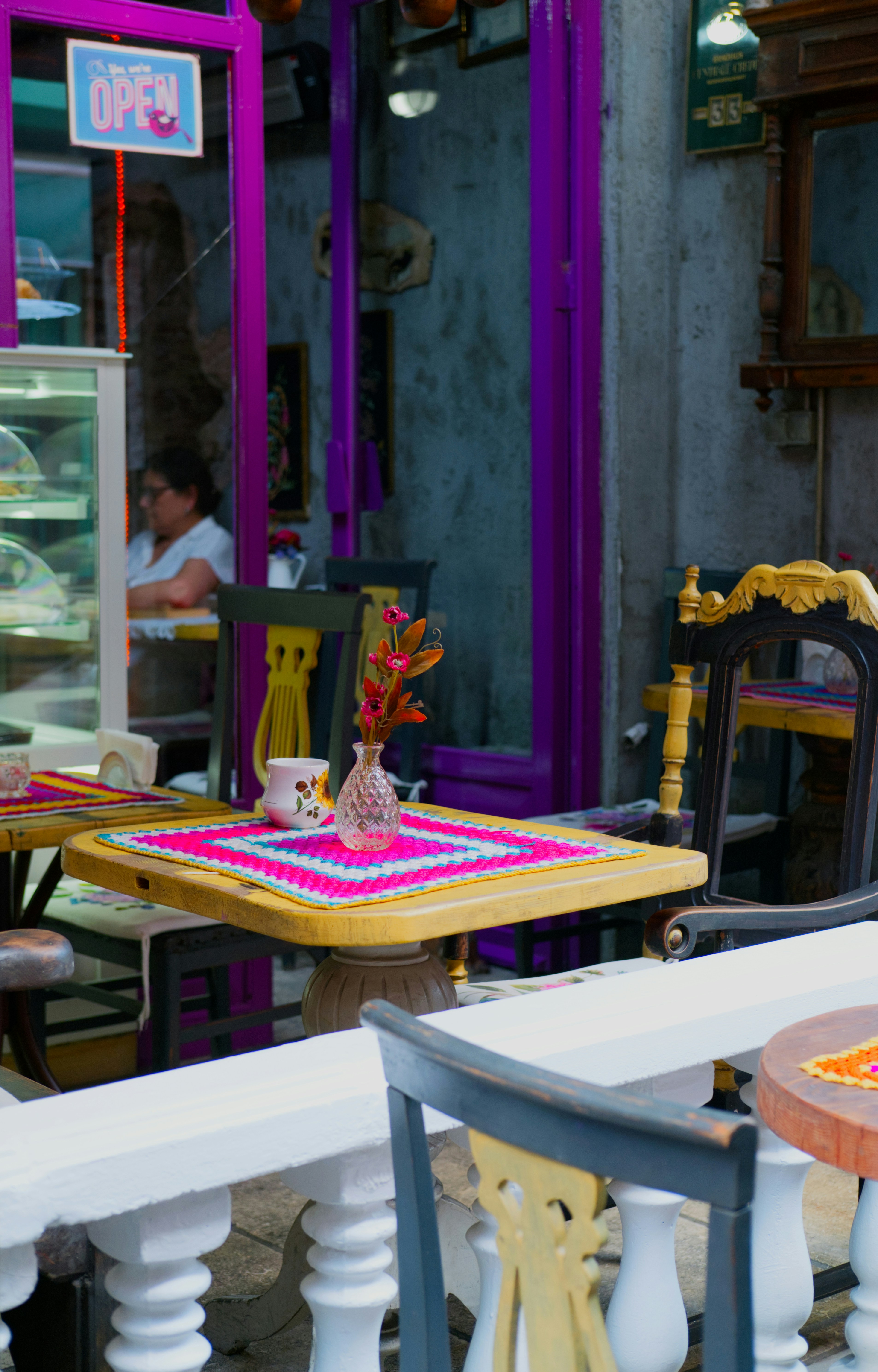 Colorful Café Tables Amid Purple Doorway and Scenic Outdoor Seating