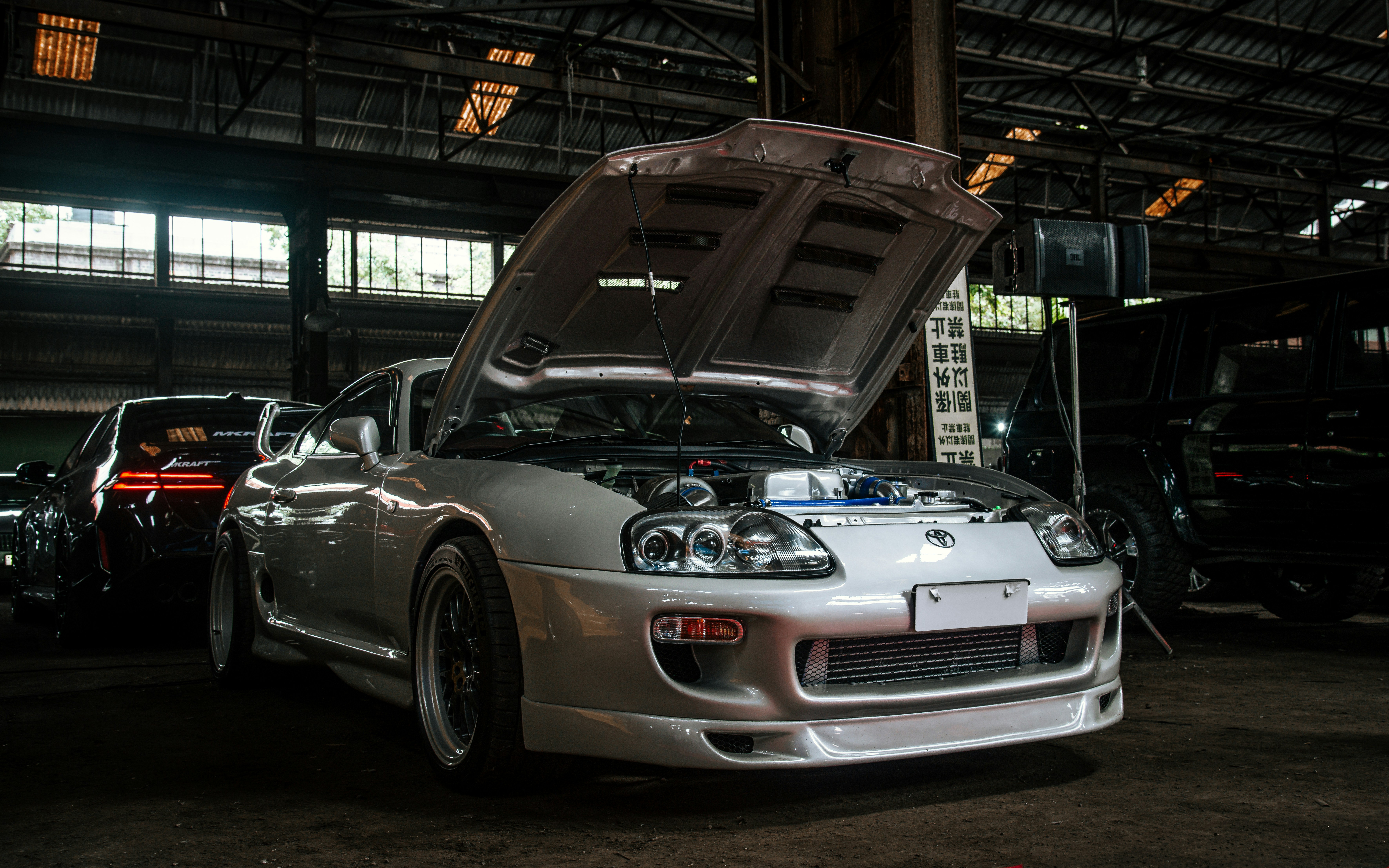 Under the Hood: A Silver Classic Car Reigns in a Dim Workshop