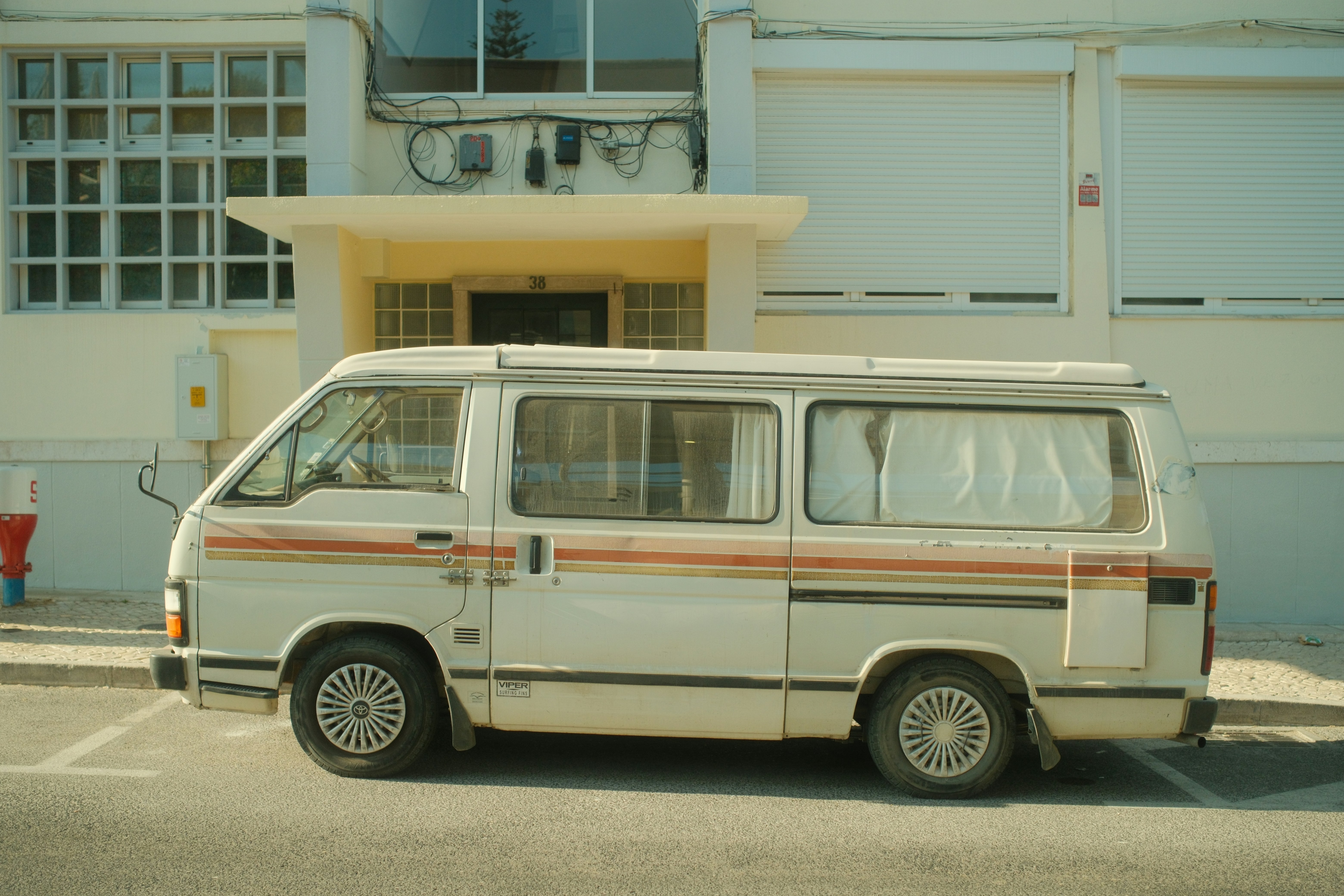 Vintage Camper by the Sunlit Urban Facade