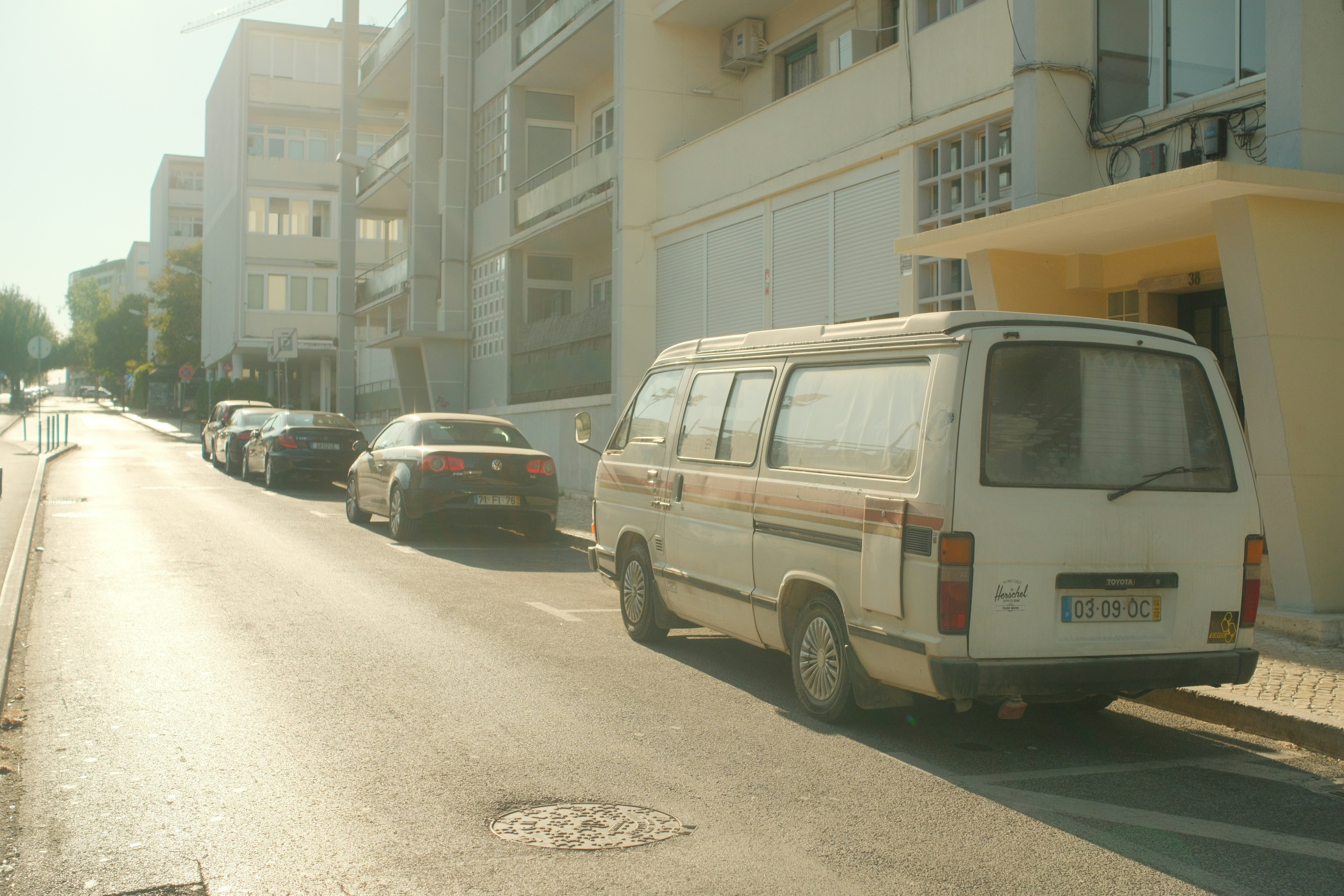 Sunlit Street Scene with a Vintage Van and Quiet Morning Traffic