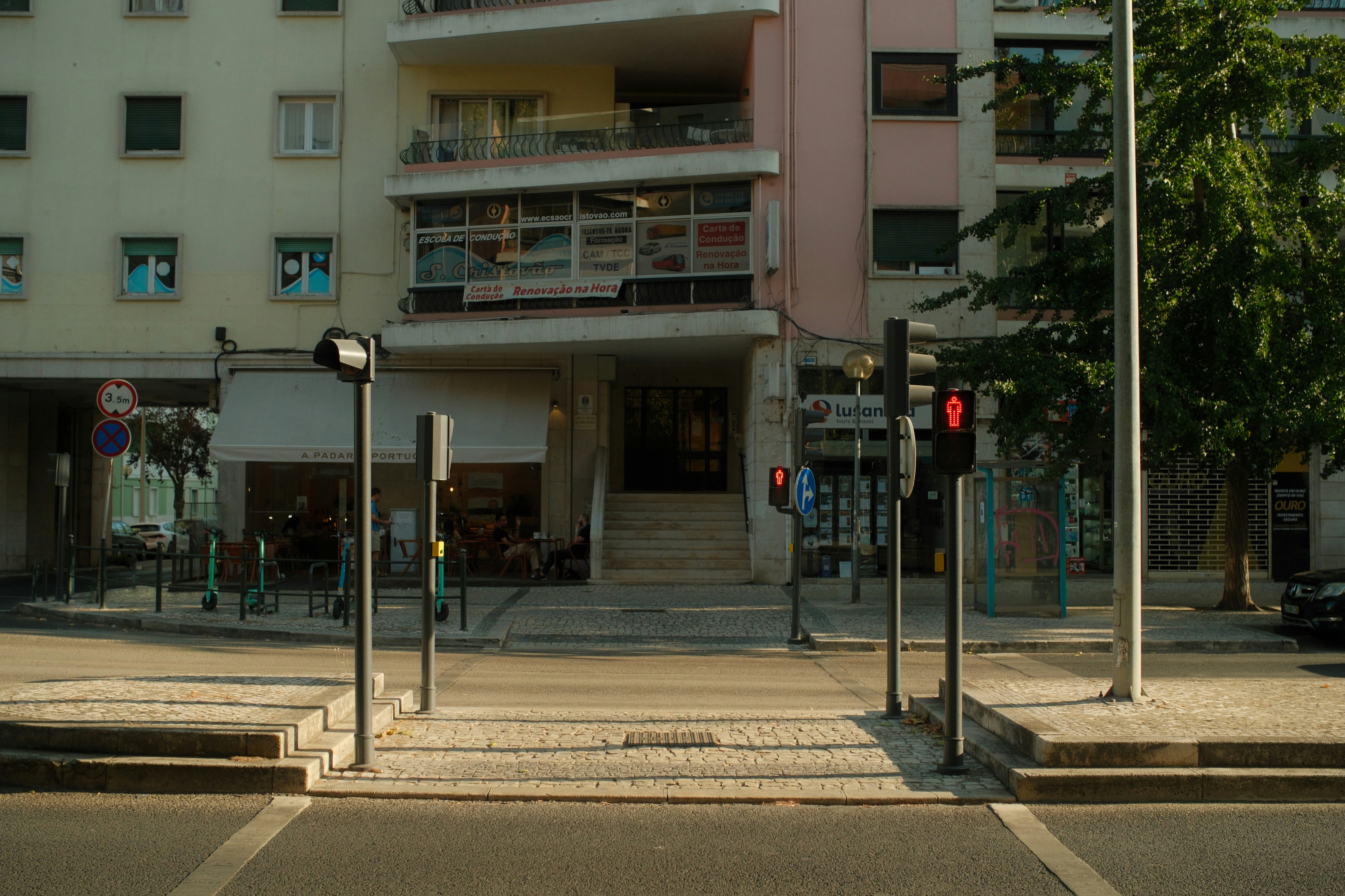 Urban storefronts and tram-stop at a sunlit street