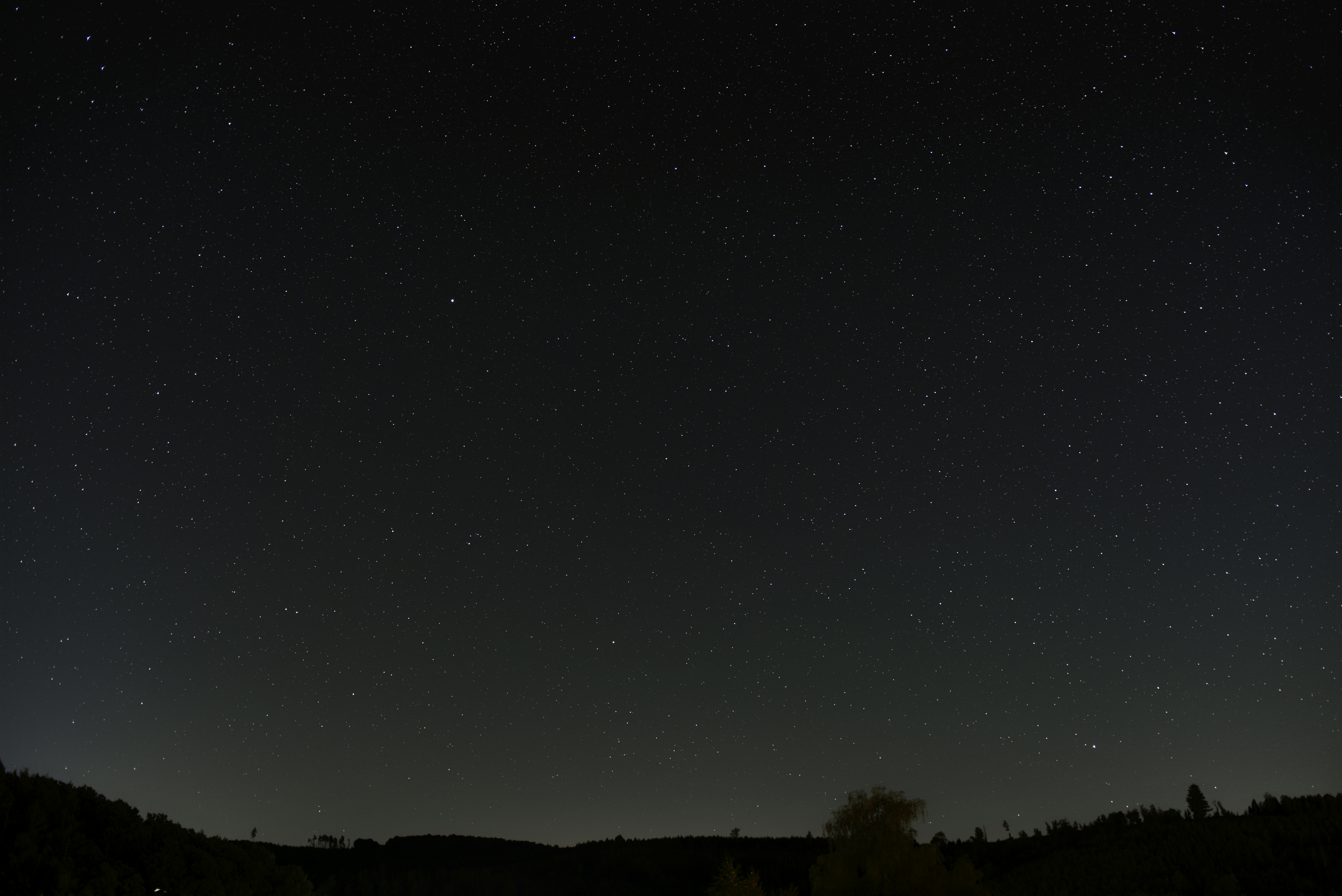 Starlit Horizon: A Quiet Night Sky Above the Silhouetted Ridge