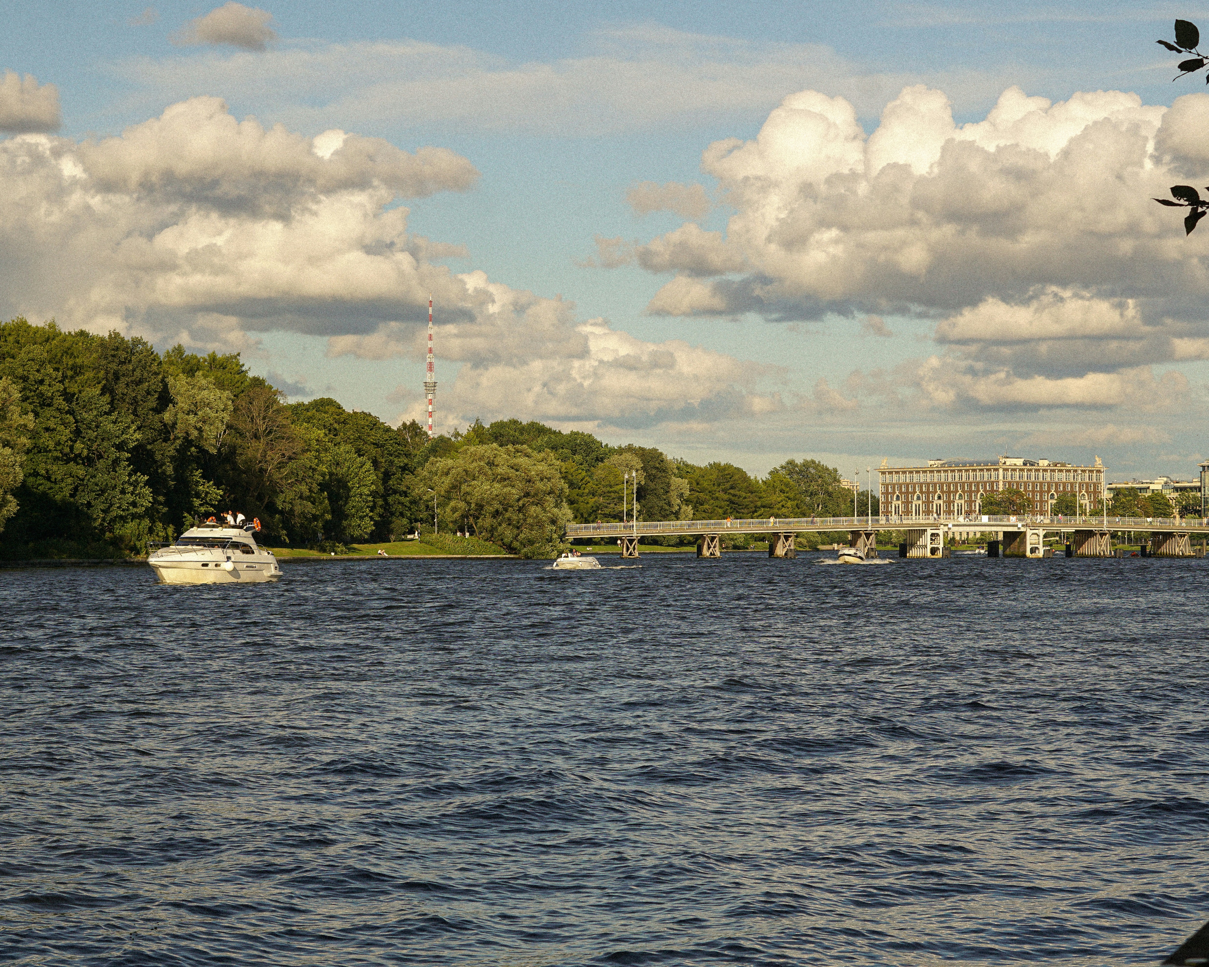 Cityscape on the River: A Boat-Dotted Horizon Under Puffy Skies