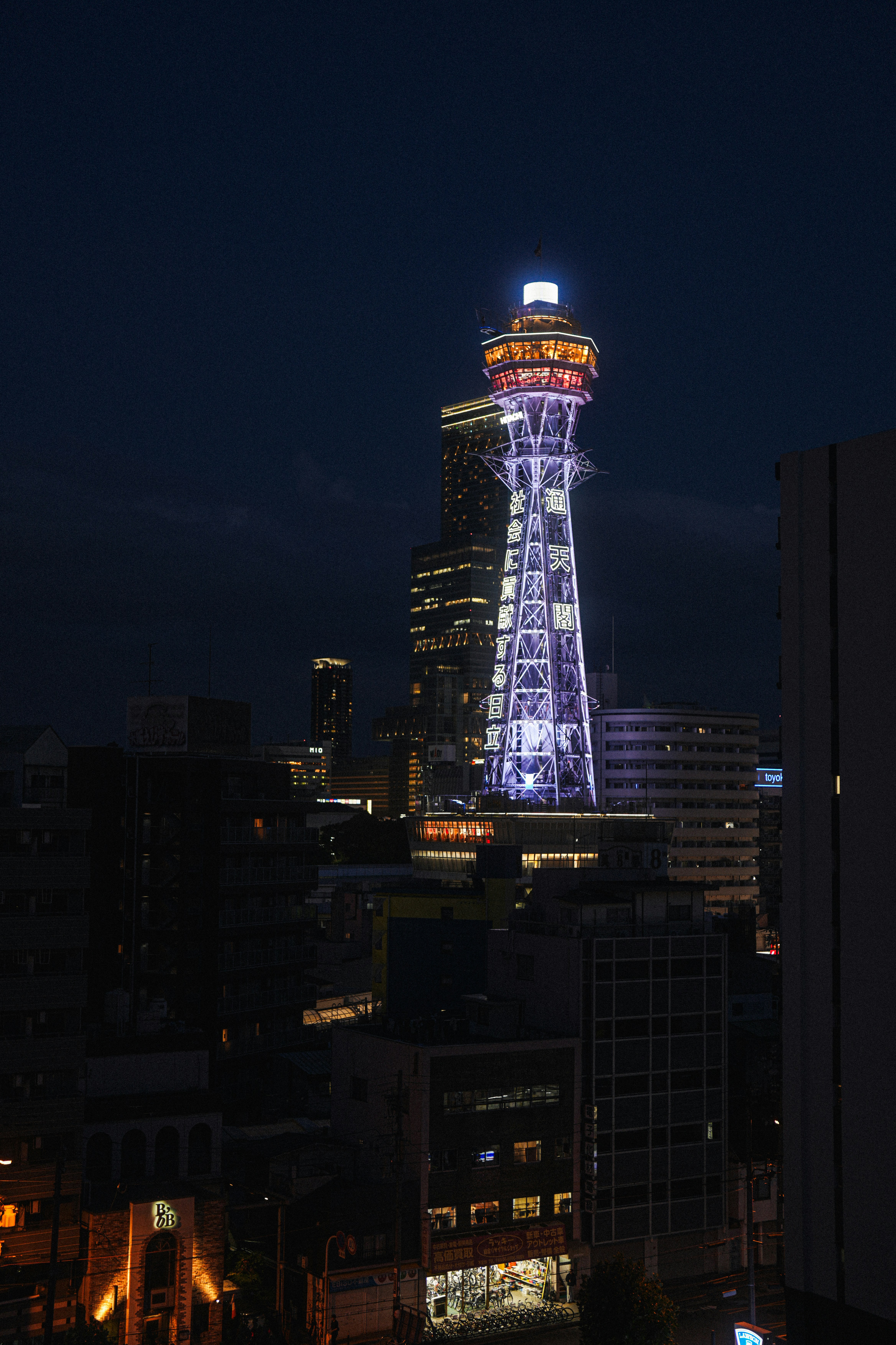 Night Bloom: The illuminated tower rising above the city silhouette