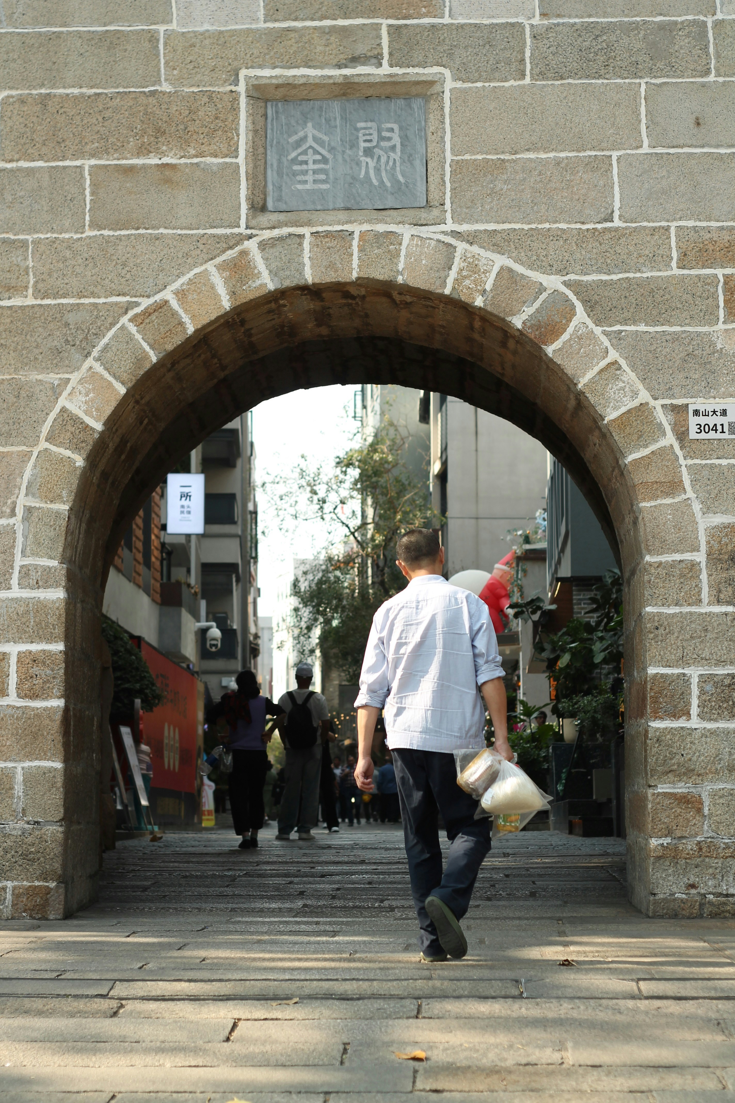 Passing Through the Stone Gate: A Quiet Street beneath an Archway
