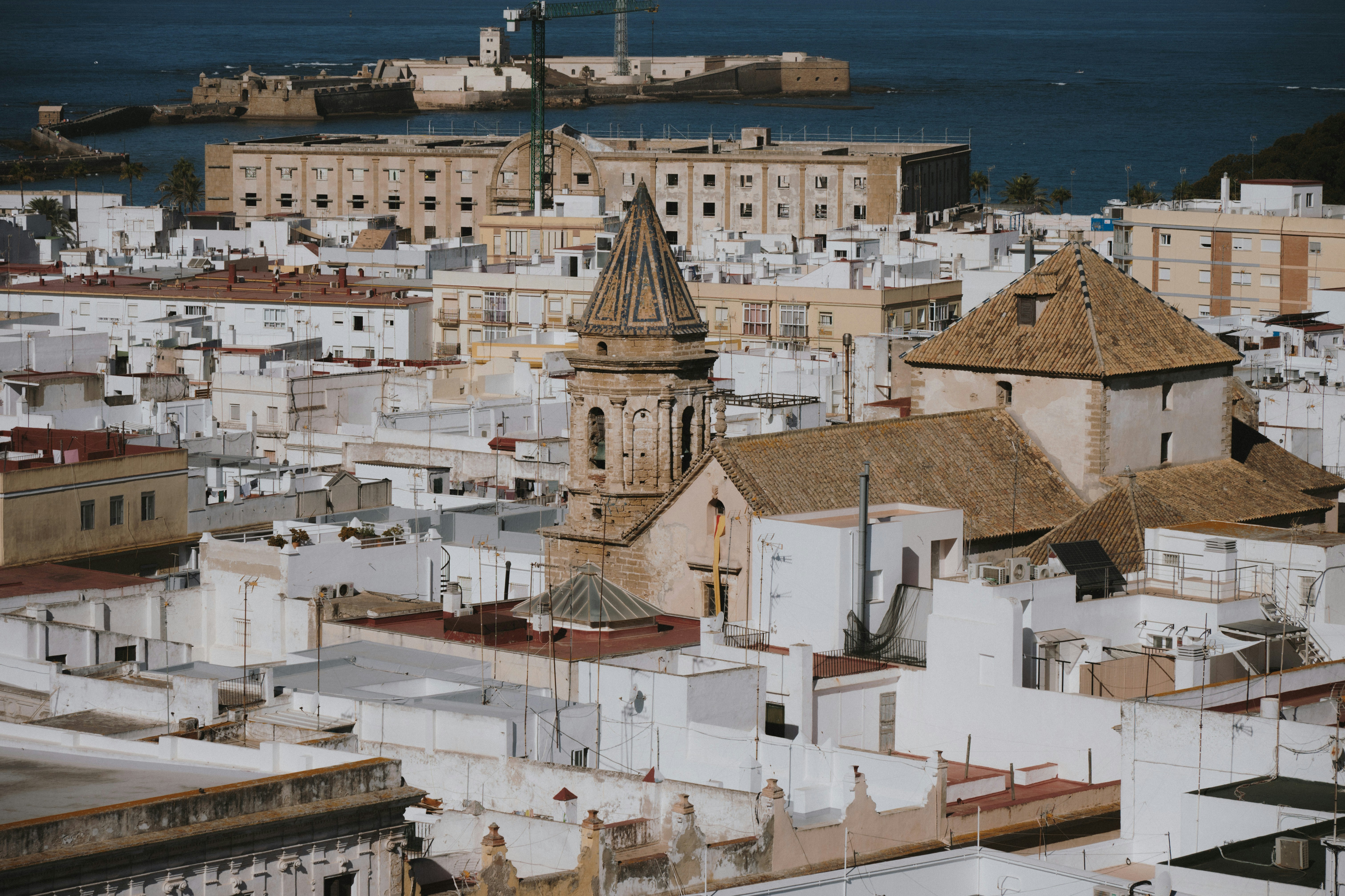 White rooftops and a church tower lingering over a coastal town