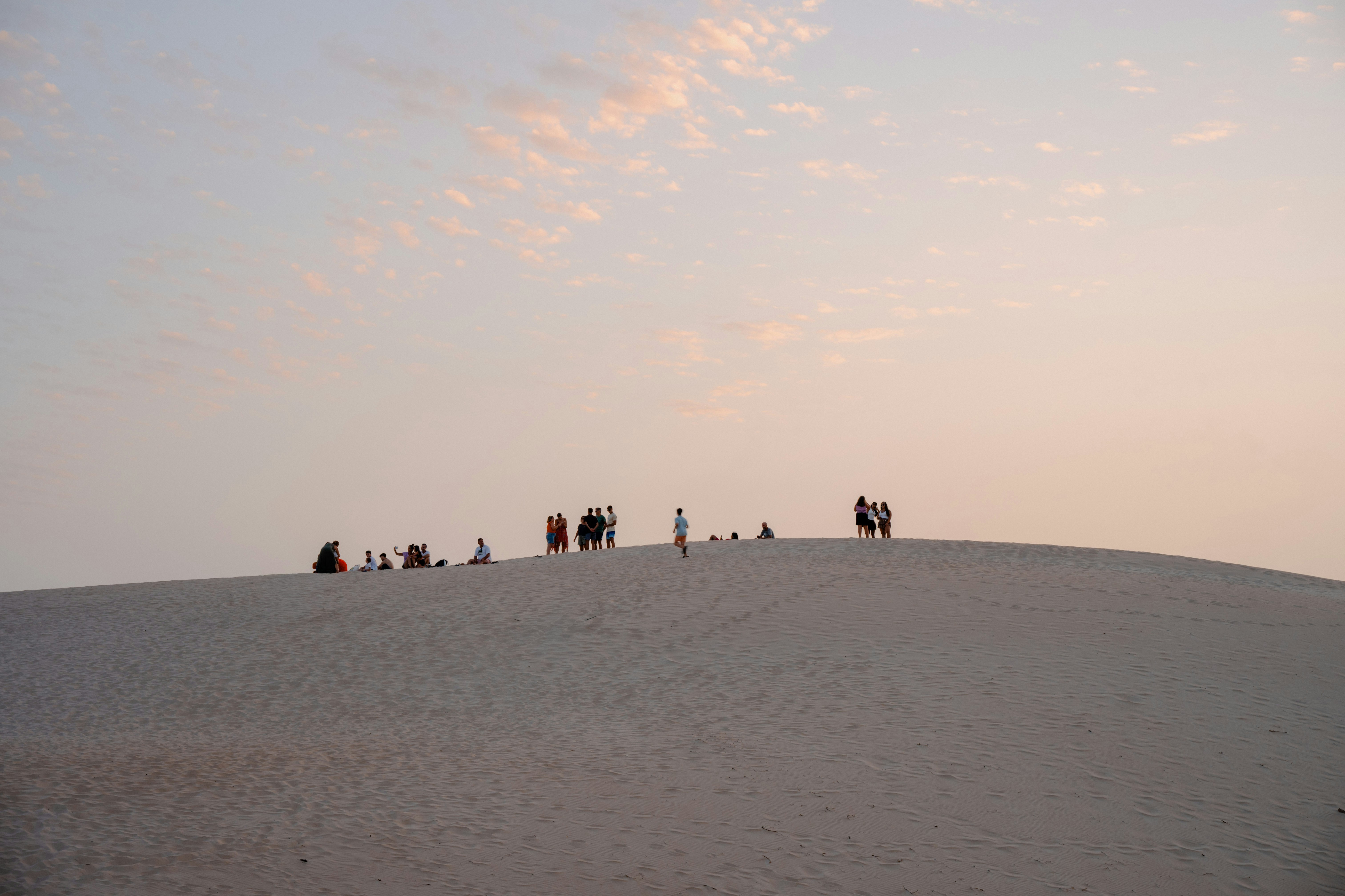 Horizon of Silhouettes: Dune Watchers at Sunset